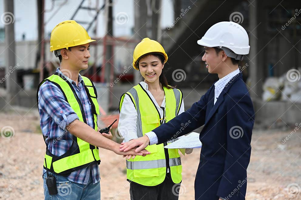 Construction Workers Stacking Hands To Motivate and Working As Teamwork ...