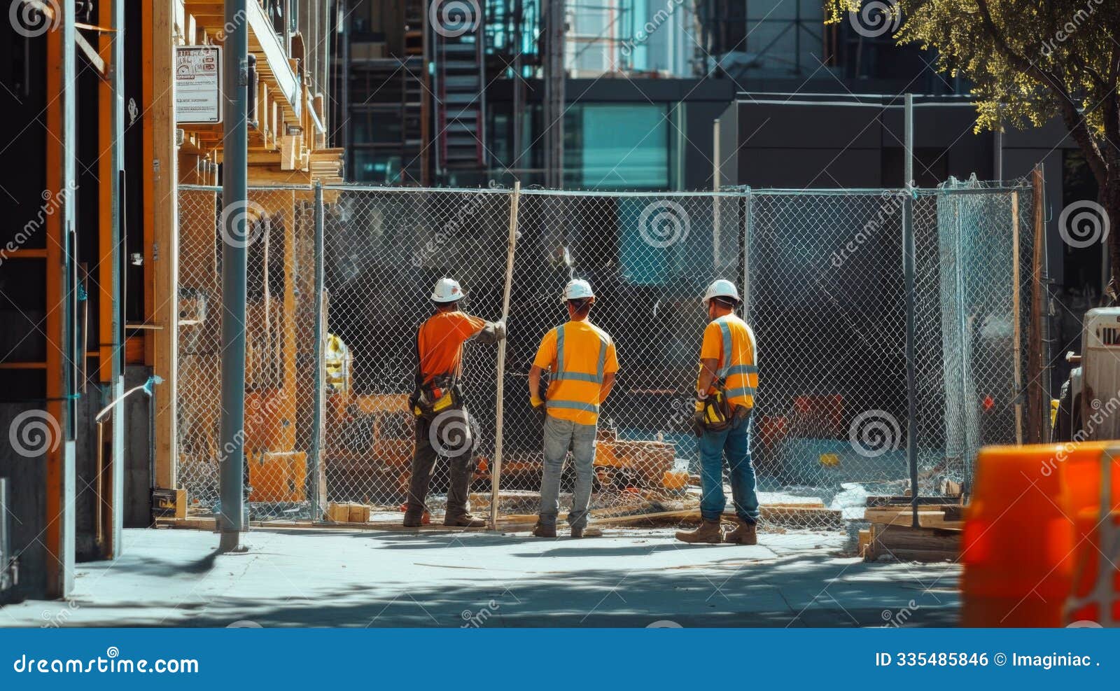 Construction Workers Standing in Front of a Chain Link Fence Stock ...