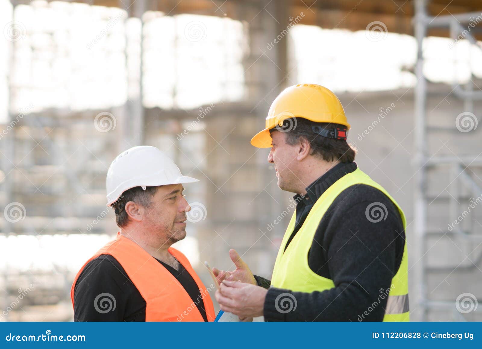 Construction Workers Talking on Construction Site Stock Photo - Image ...