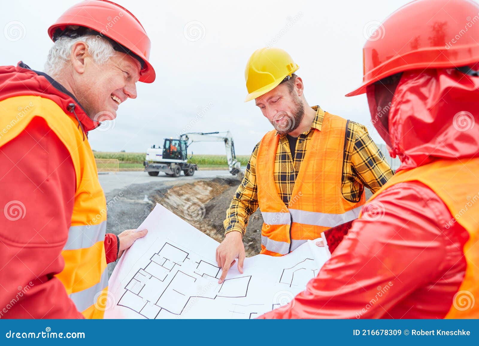Construction Workers Team with Floor Plan at House Construction ...