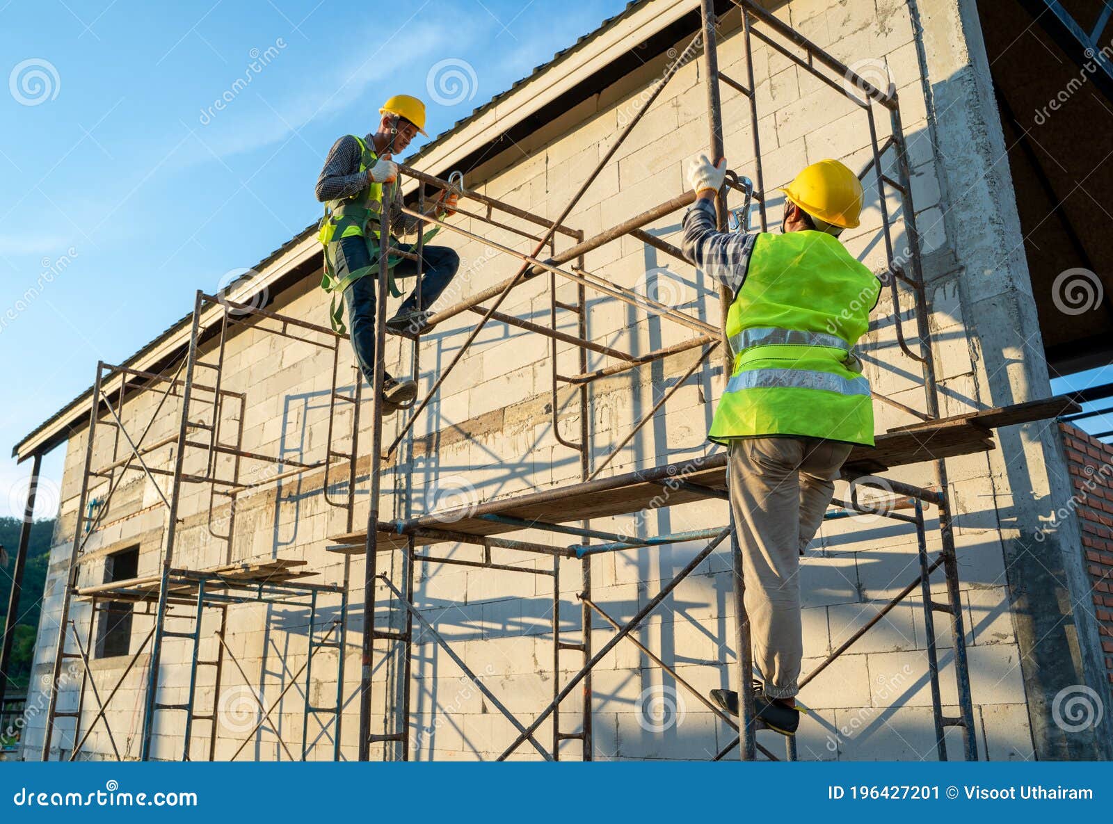 Construction Workers in Uniform and Safety Equipment Working on ...