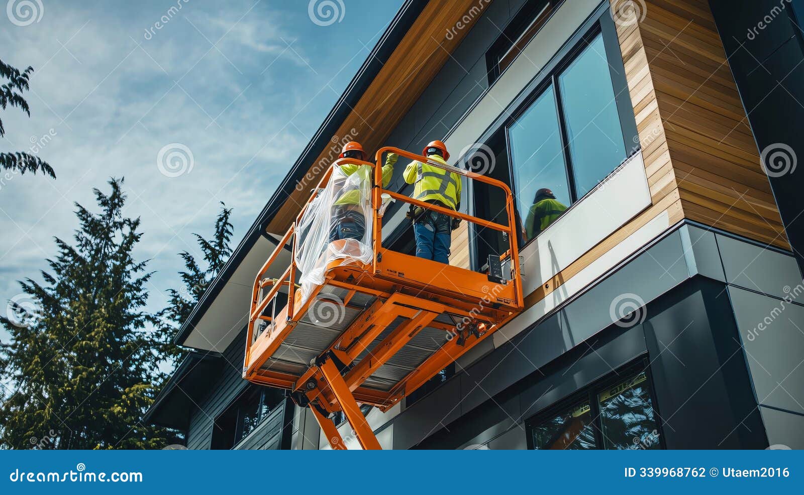 Construction Workers Using Scissor Lift Installing Windows on Modern ...