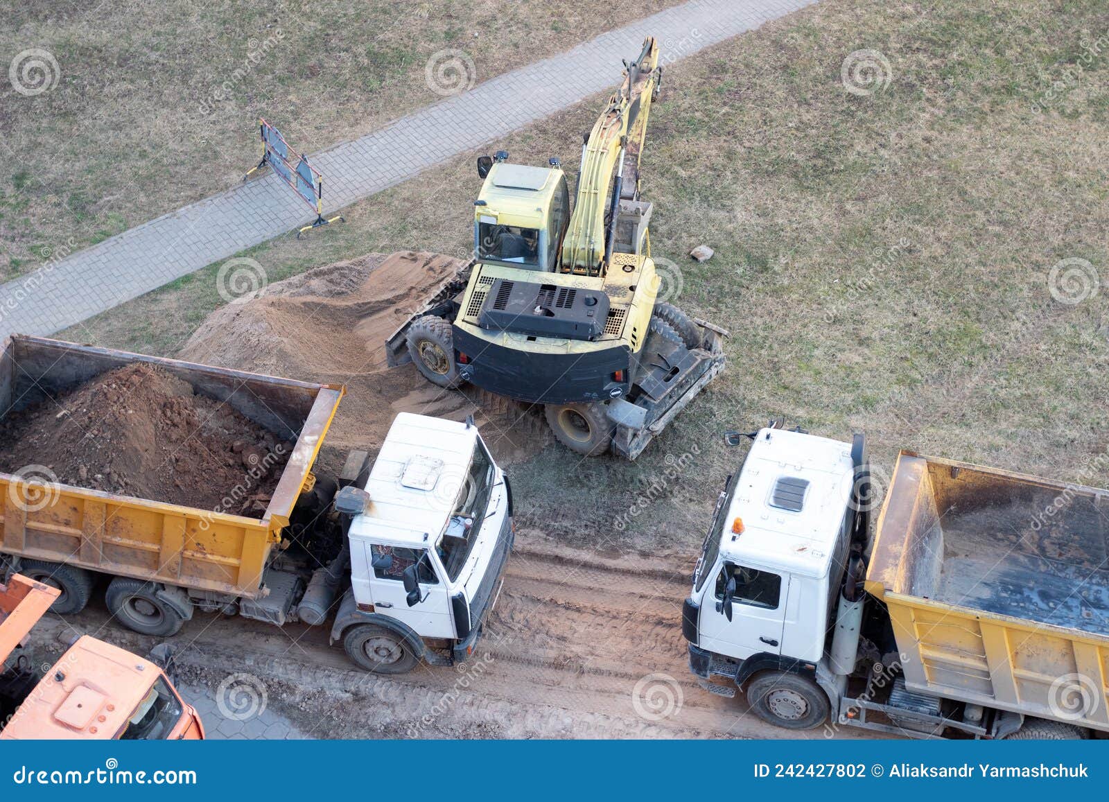 Construction Works for Laying Pipes. Dump Trucks Involved in the ...