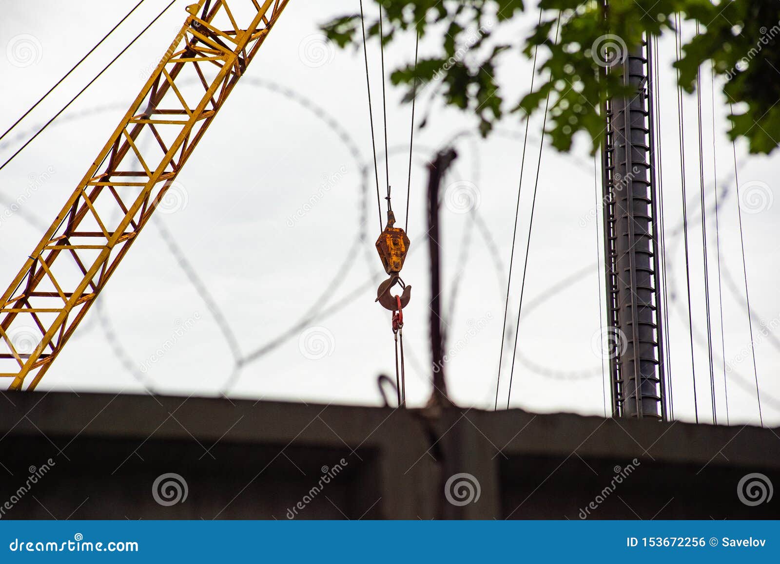 Construction Yellow Crane Behind a Barbed Wire Fence Stock Photo ...
