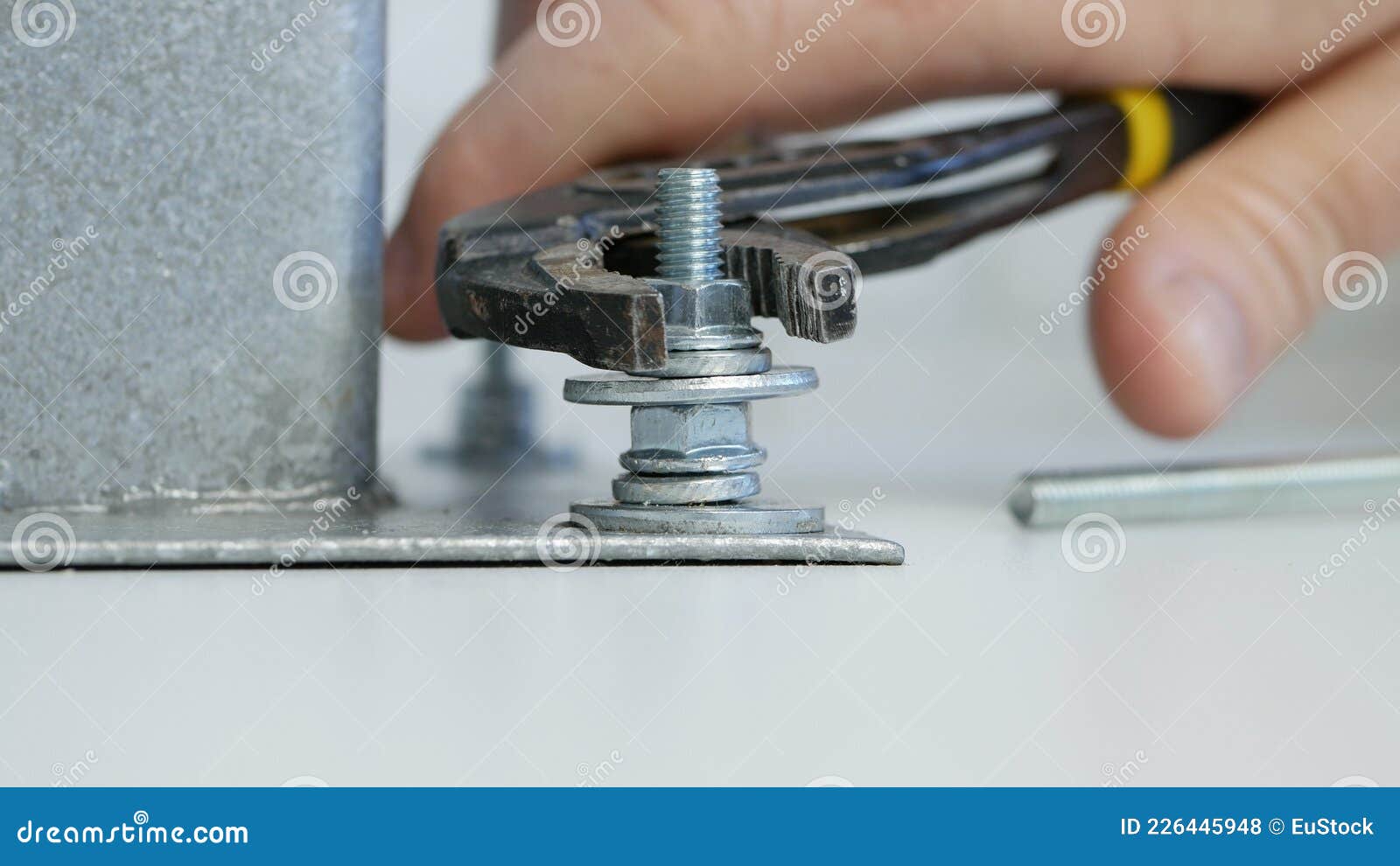 Constructor Screwing A Nut Onto A Metal Screw And Tightly Secure A Part ...