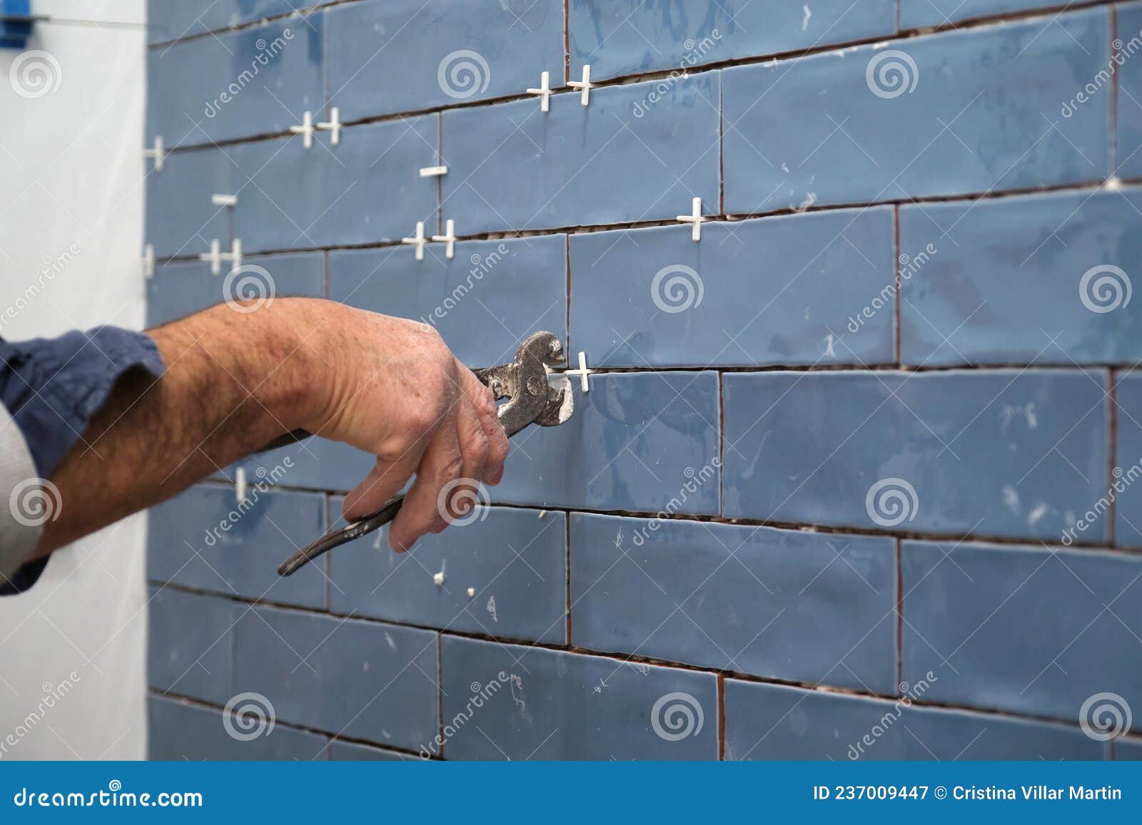 Constructor Worker Hand Removing the Separation between Tiles on the ...