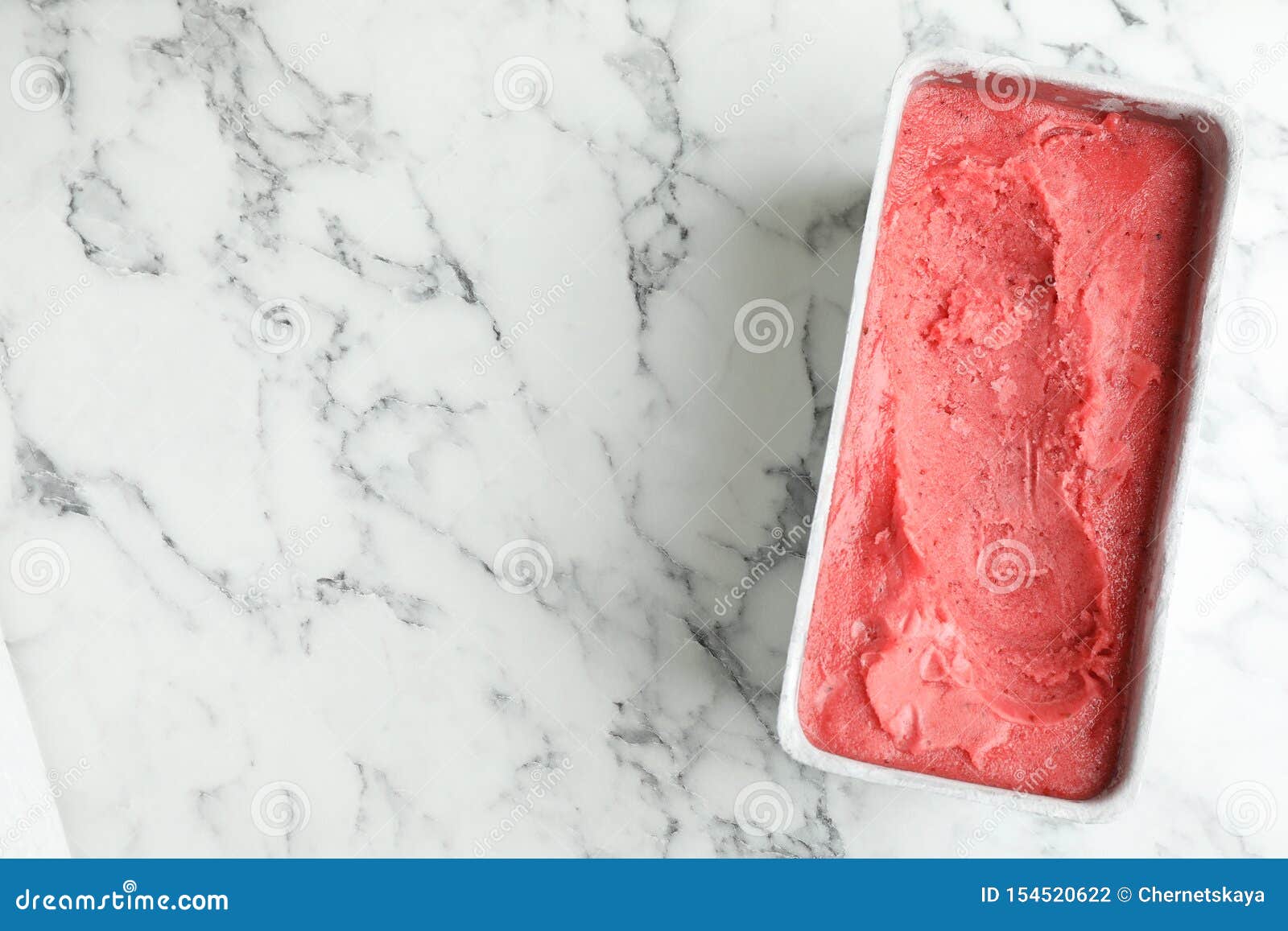 Container with Delicious Pink Ice Cream on Marble Table, Top View ...