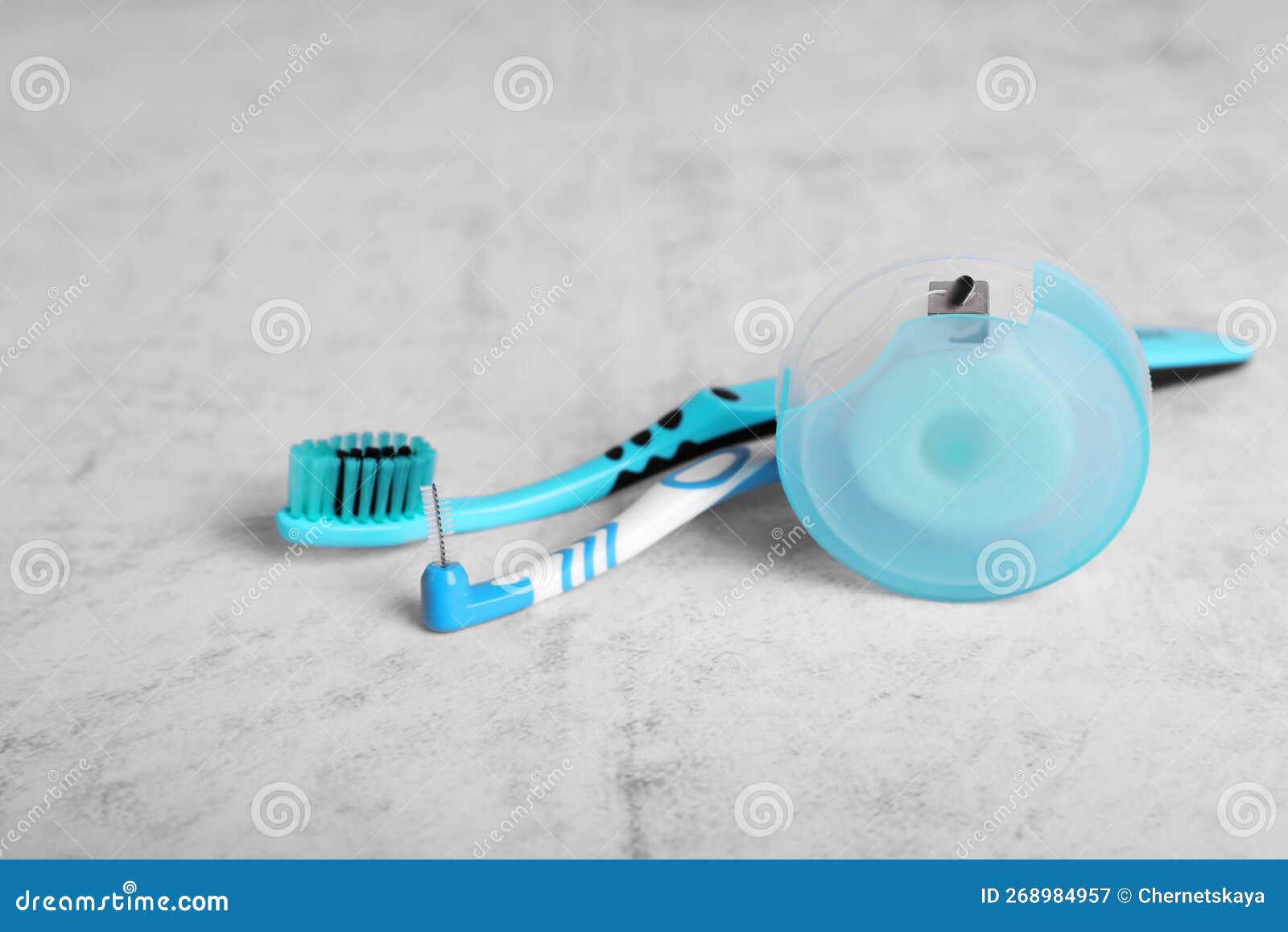 Container with Dental Floss and Toothbrushes on Light Grey Textured ...