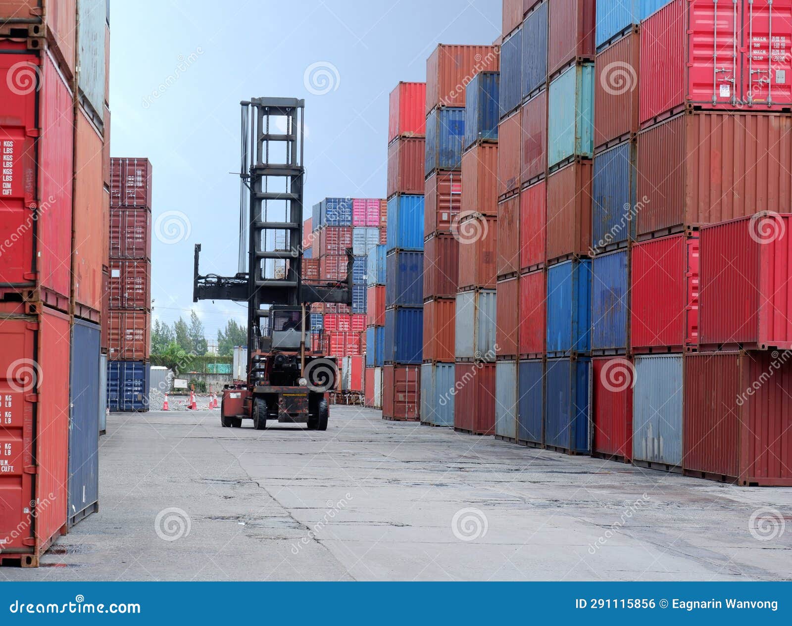 A Container Forklift Sits Behind a Stack of Containers Stock Photo ...