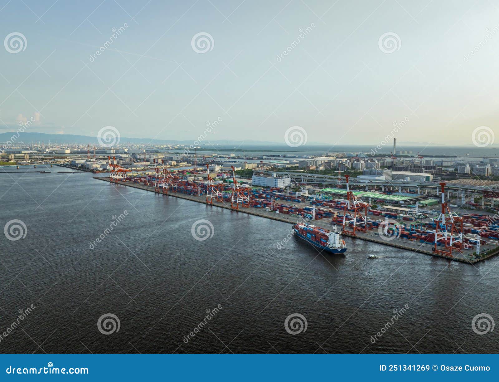 Container Ship Maneuvers into Docking Position Under Loading Cranes ...