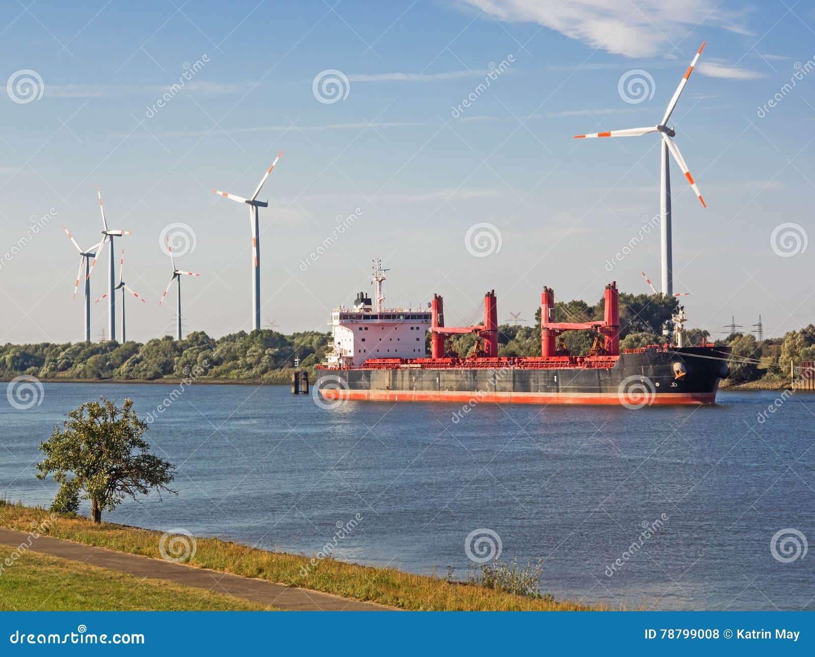 Container Ship on a River with Wind Turbines in the Background Stock ...