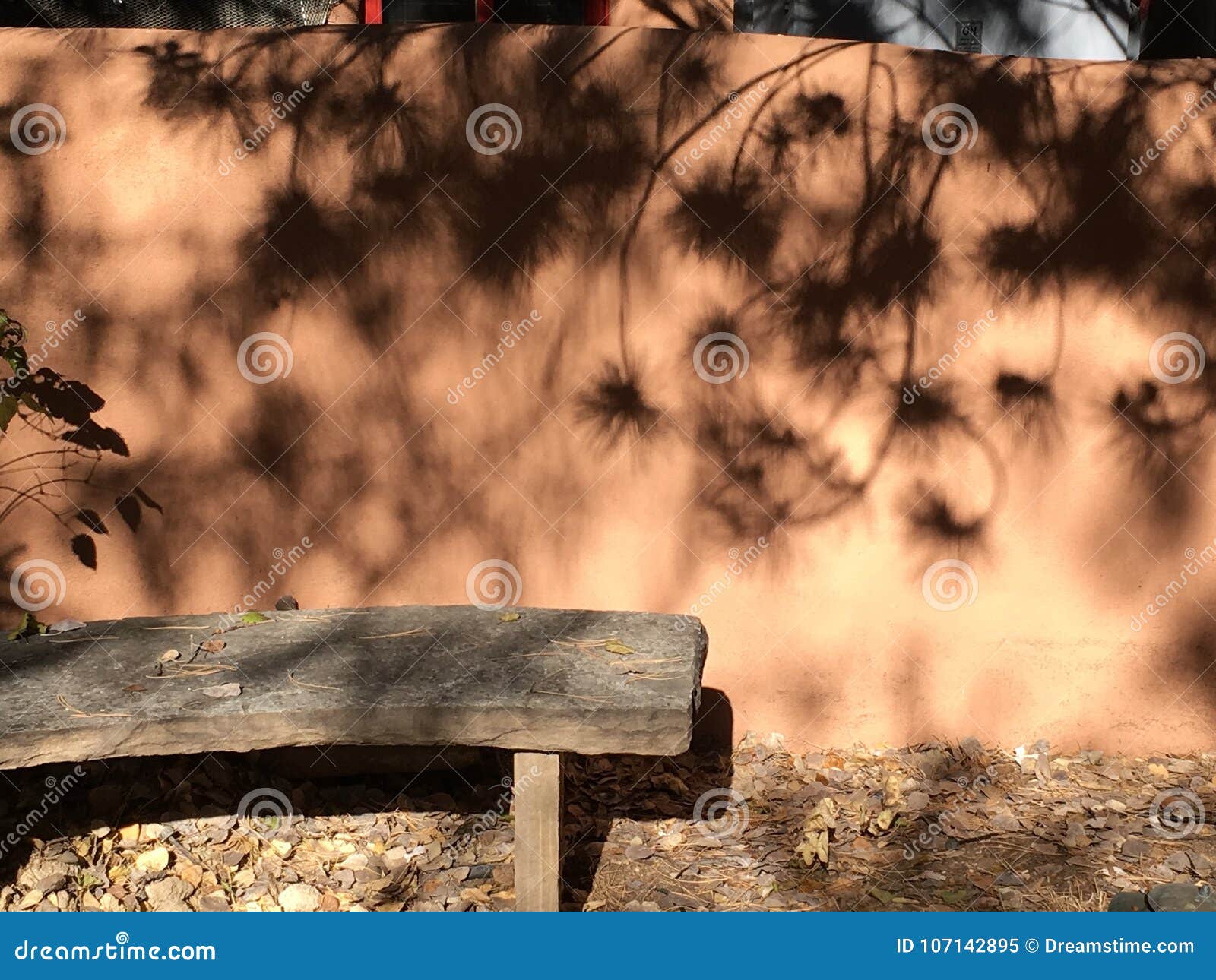 Contemplative Adobe Wall and Stone Bench Stock Image - Image of boughs ...