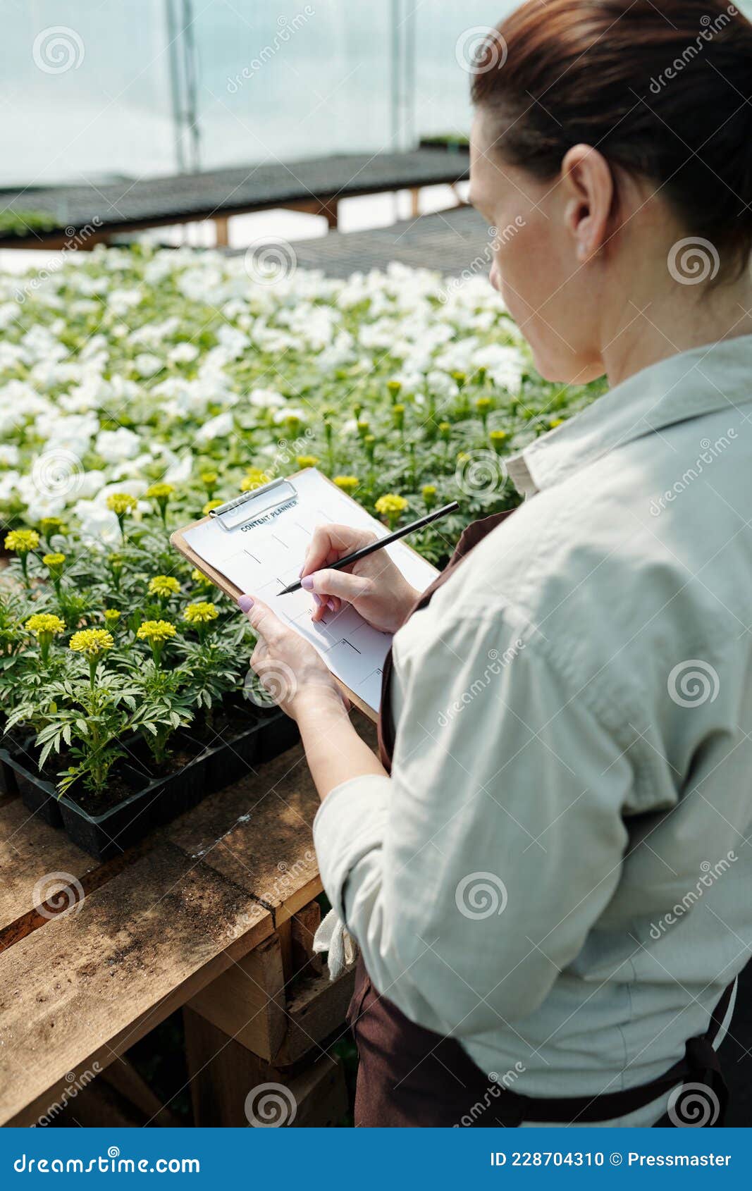 Contemporary Farmer Making Notes on Paper while Standing by Workplace ...