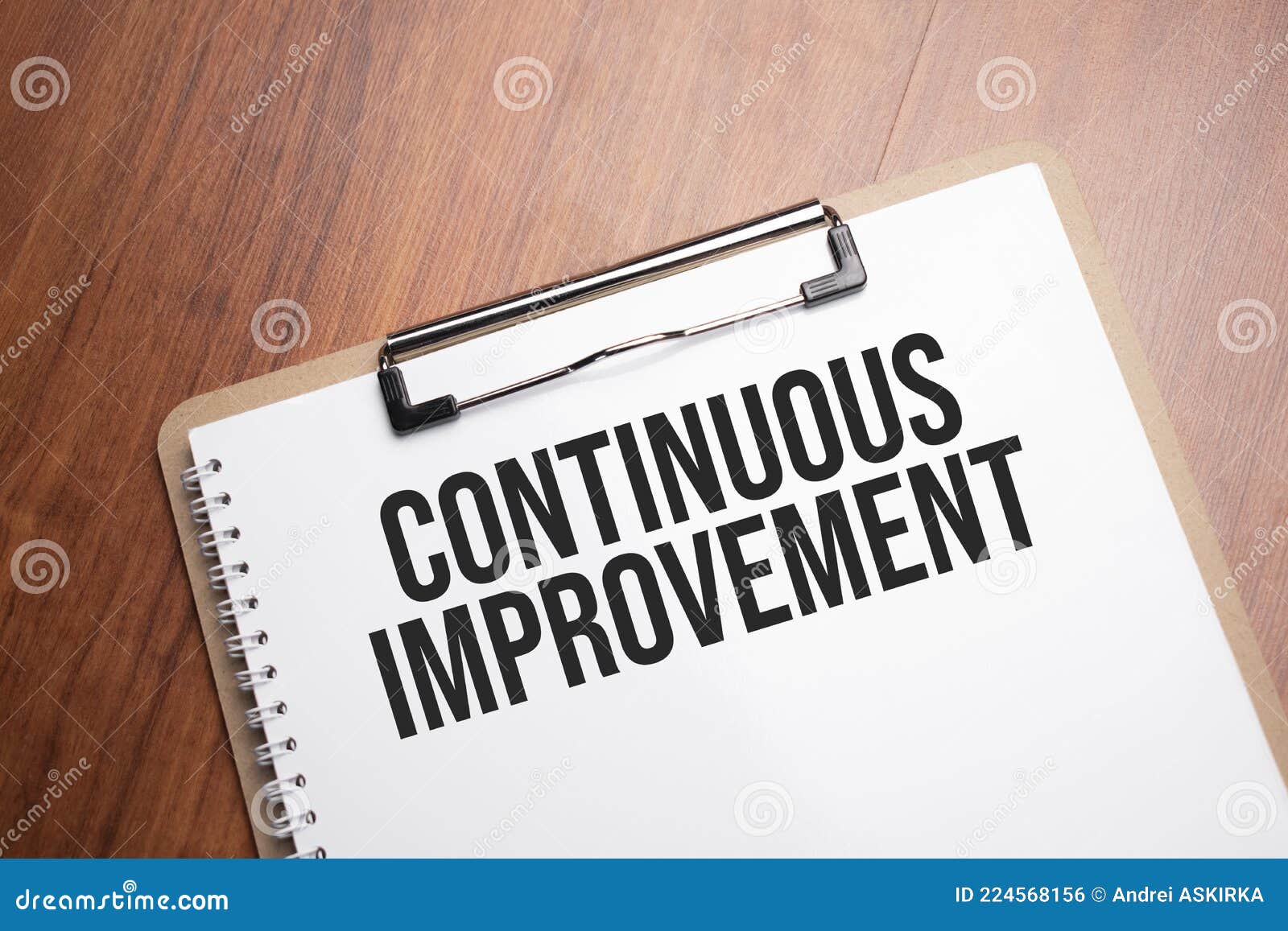 Continuous Improvement Text on White Paper on the Wood Table Stock ...