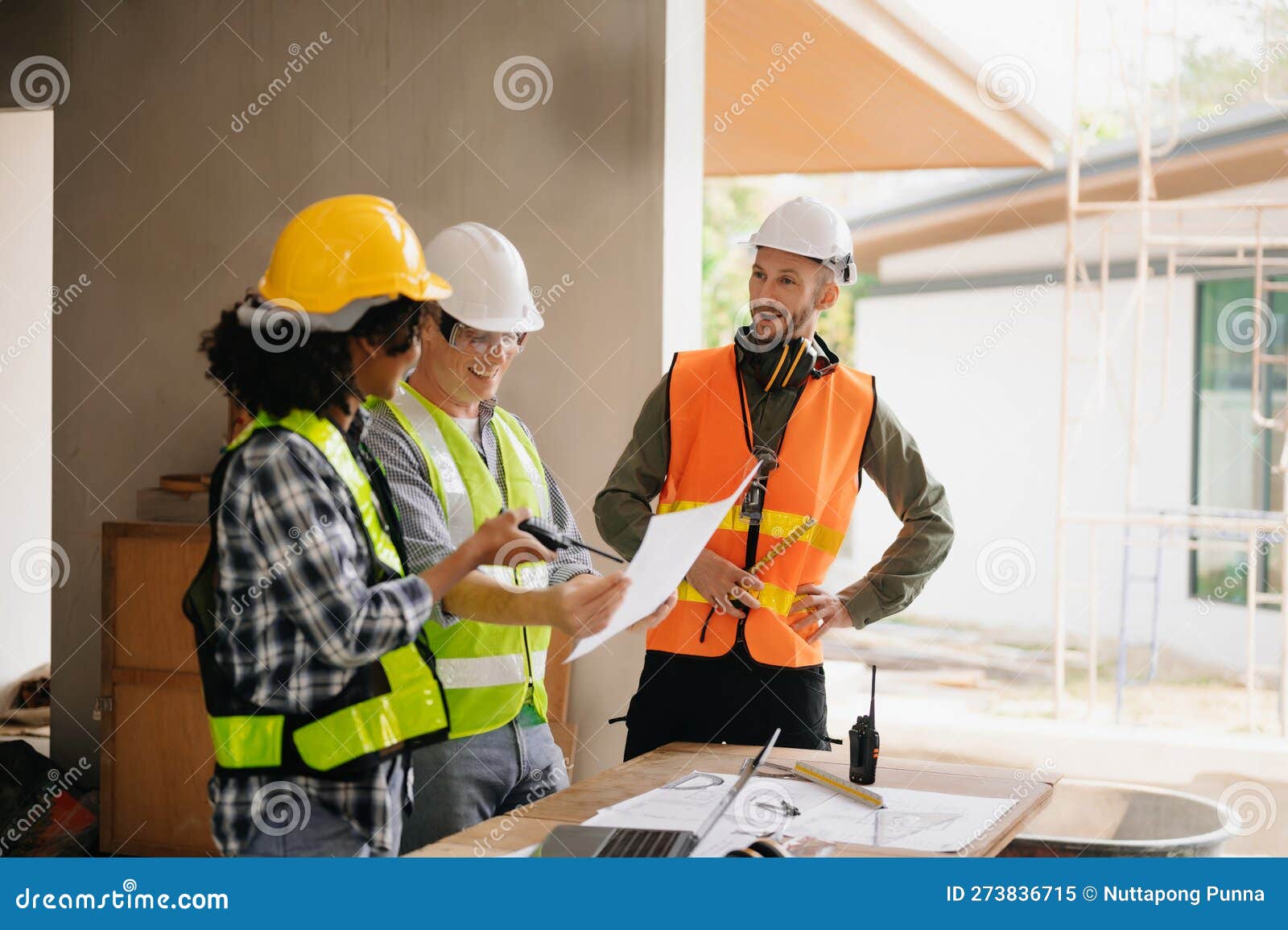 Contractor and Architect Looking at Plan, Tablet, Laptop and Talking ...