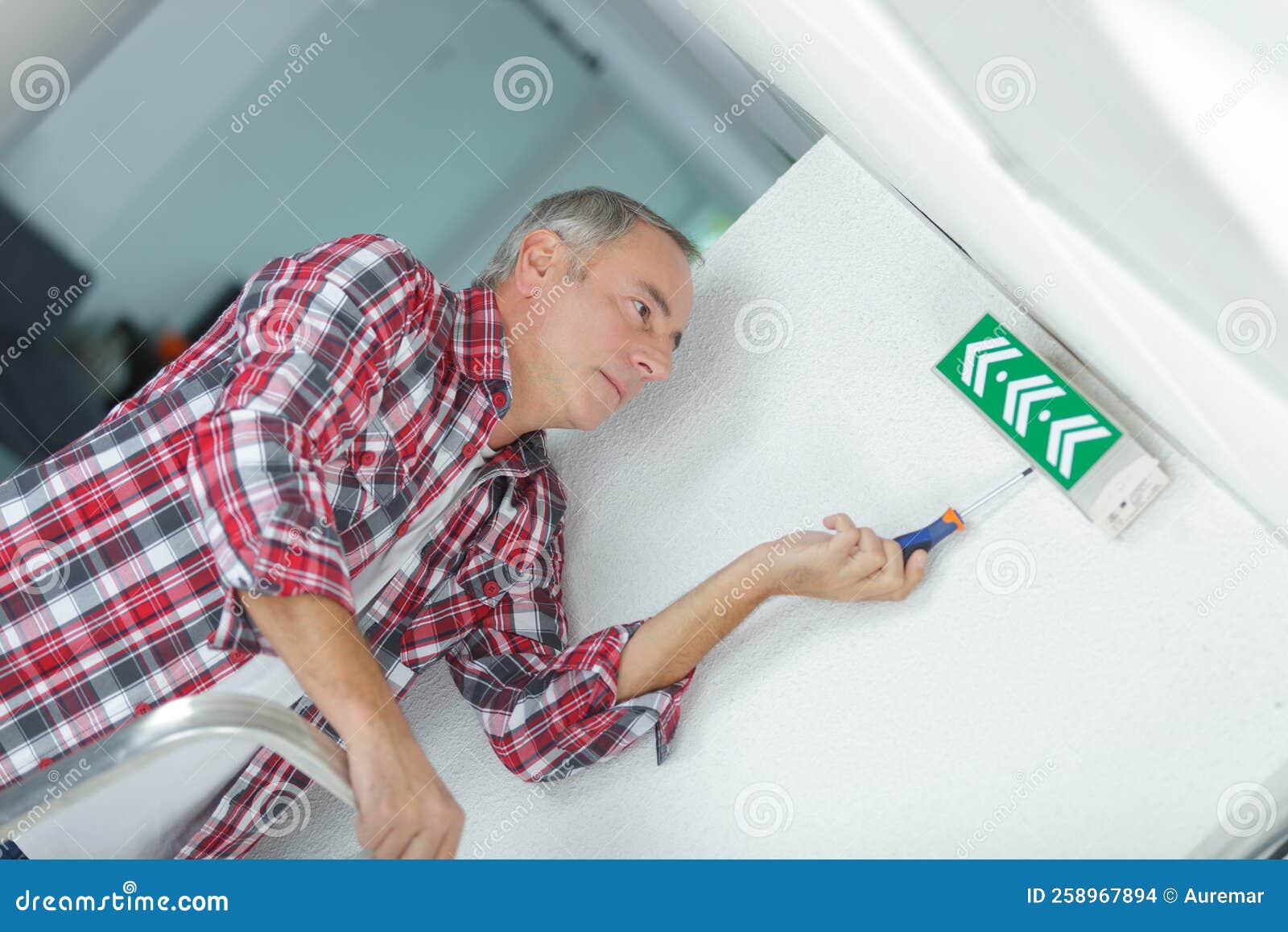 Contractor Installing Green Emergency Fire Exit Sign Stock Photo ...