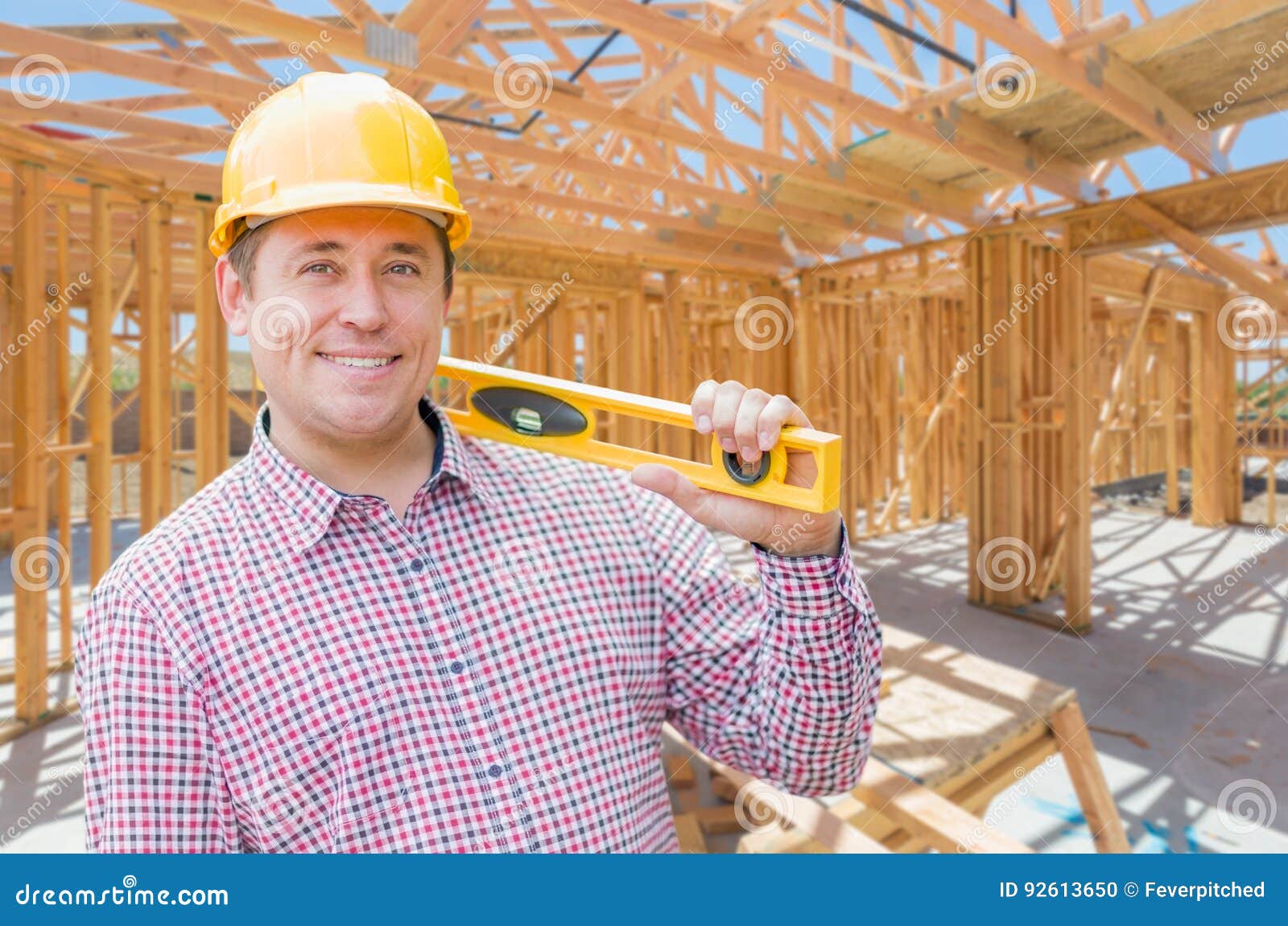 Contractor with Level on Site Inside New Home Construction Framing ...