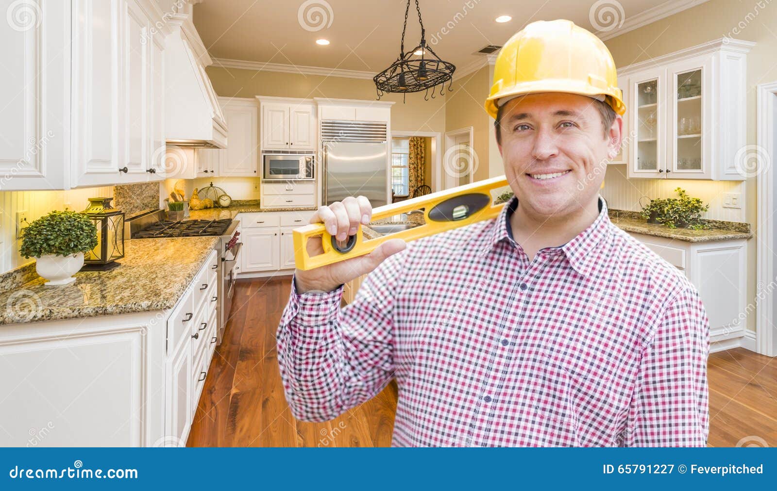 Contractor with Level Wearing Hard Hat Standing in Custom Kitchen Stock ...