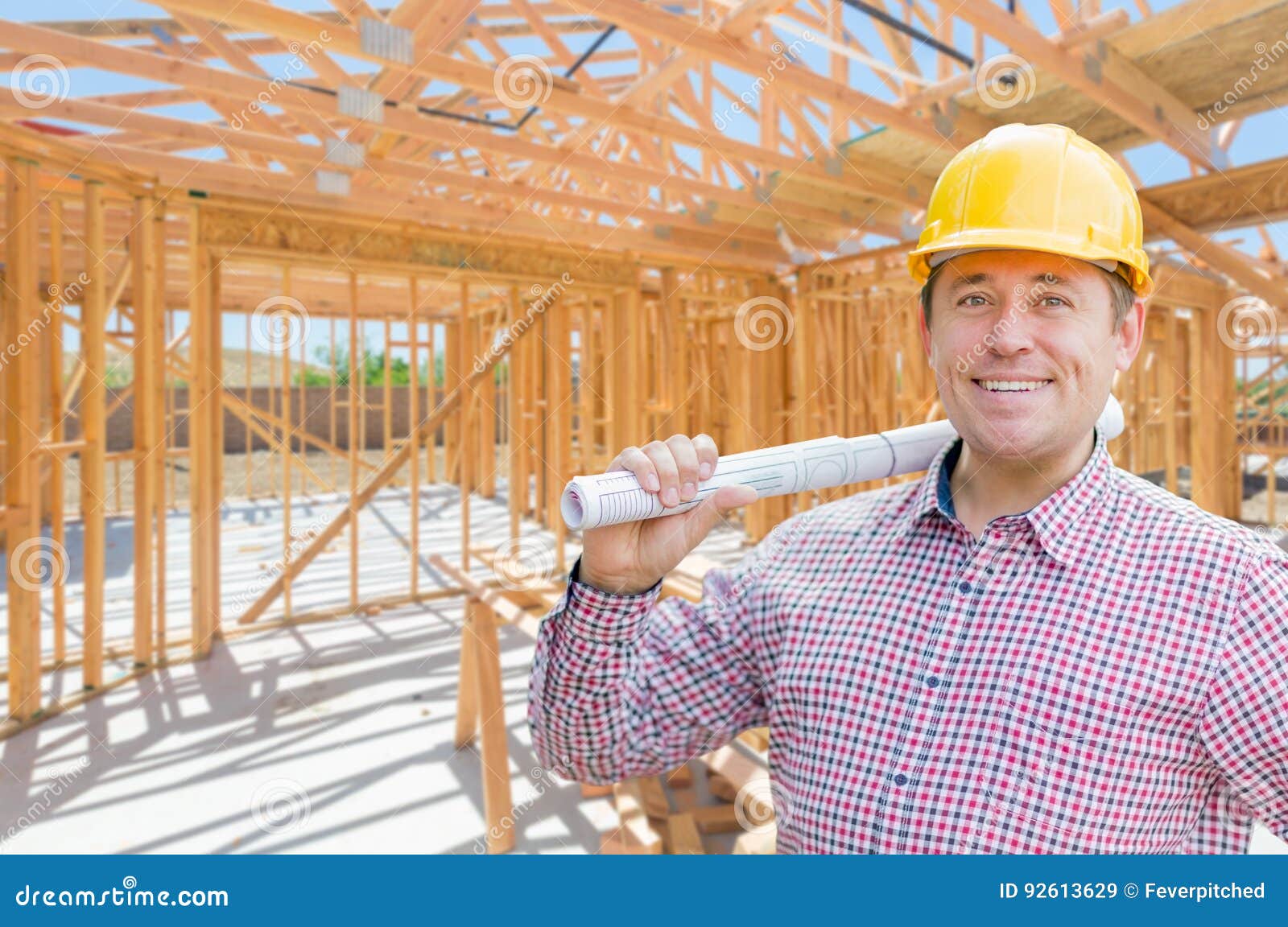 Contractor with Plans on Site Inside New Home Construction Framing ...