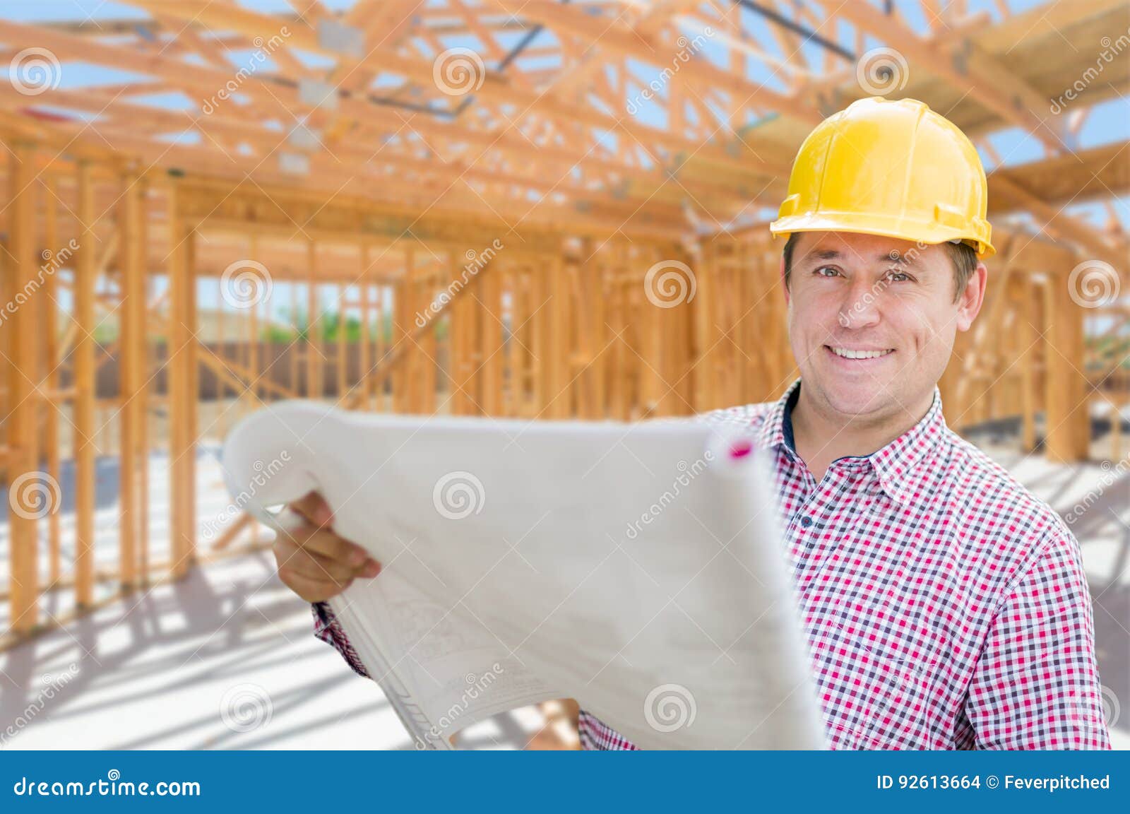 Contractor with Plans on Site Inside New Home Construction Framing ...