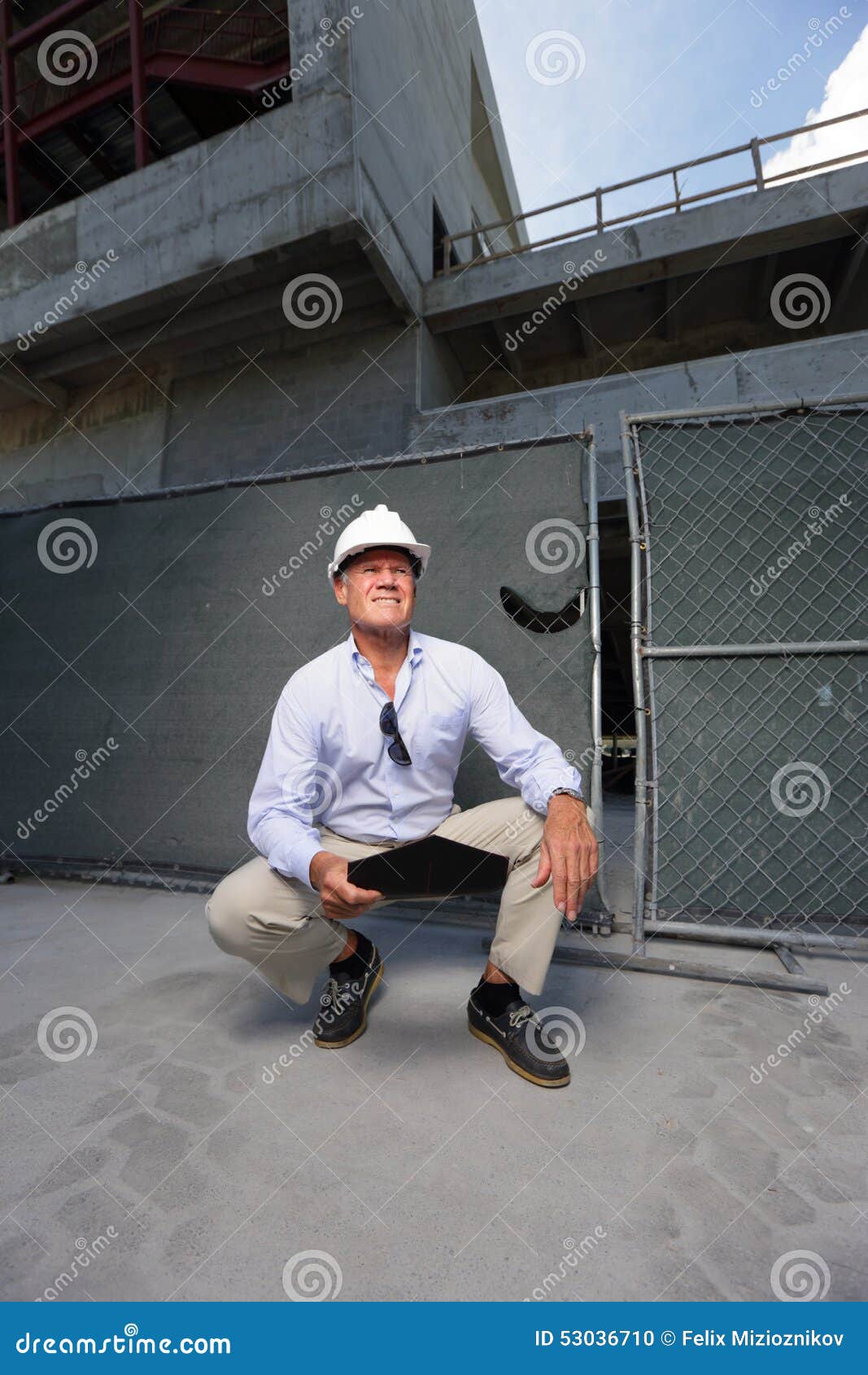 Contractor Squatting at a Construction Site Stock Photo - Image of ...