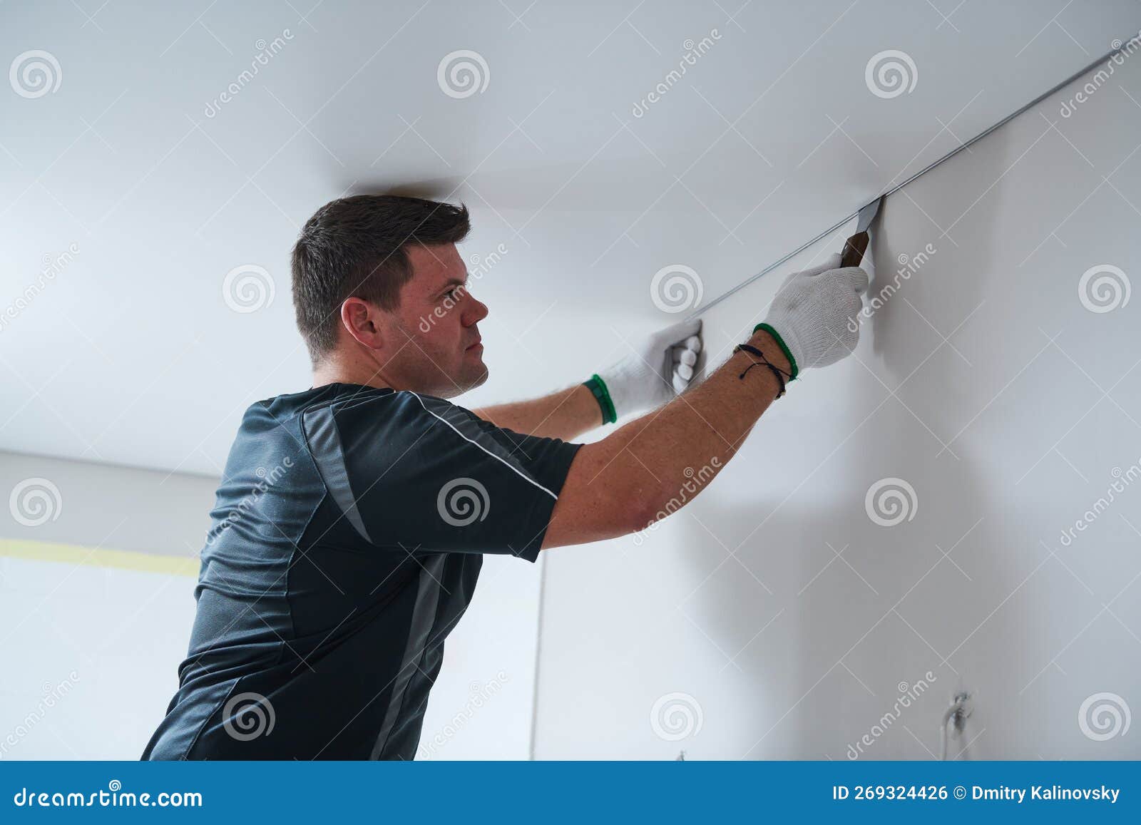 Contractor Worker Streching a Stretch Ceiling. Renovation and ...