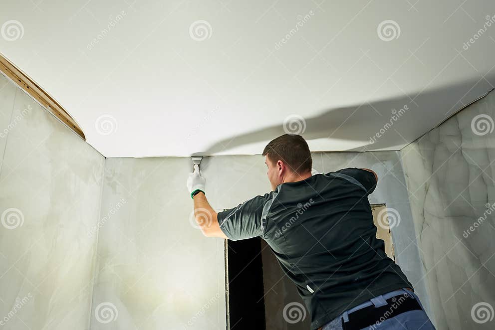Contractor Worker Streching a Stretch Ceiling. Renovation and ...