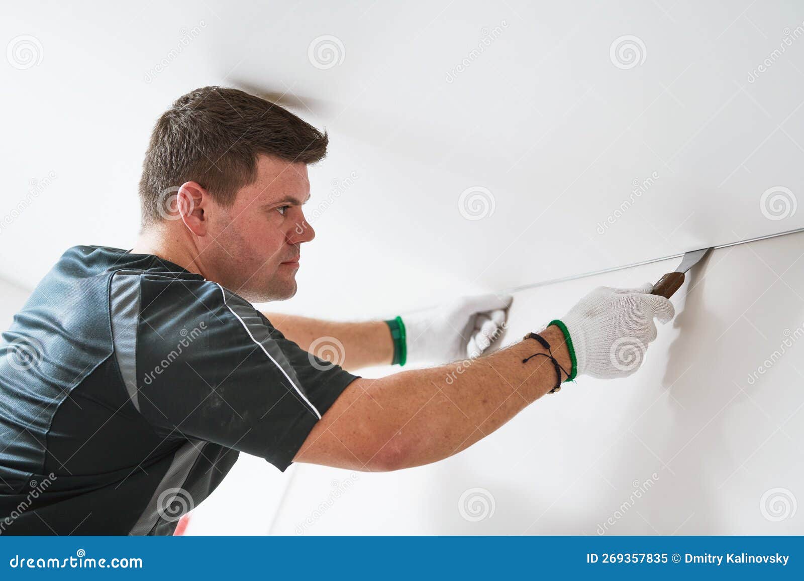 Contractor Worker Streching a Stretch Ceiling. Renovation and ...