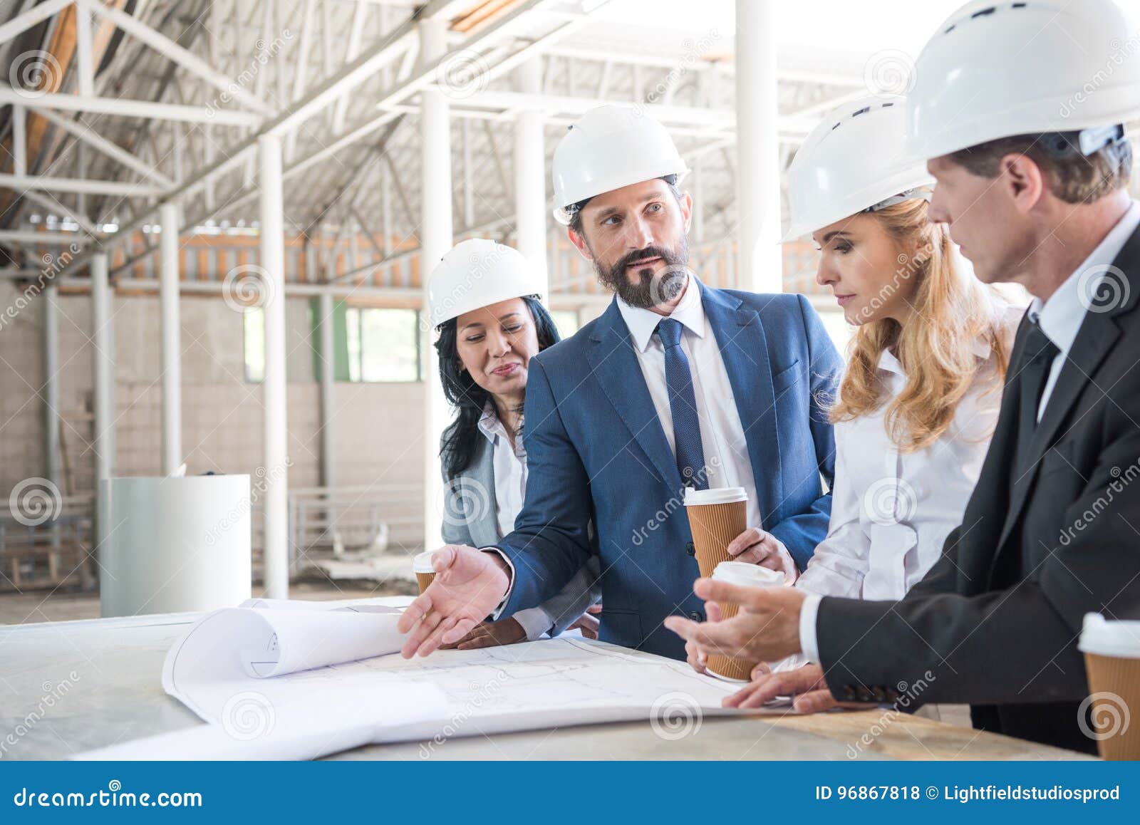 Contractors in Formal Wear Talking while Working with Blueprints at ...