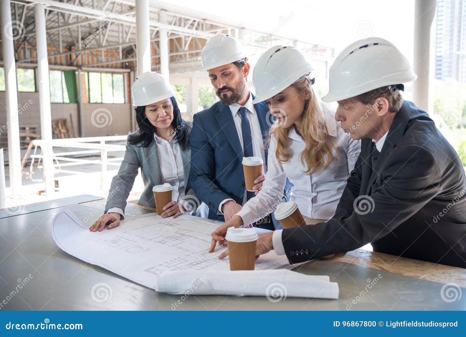 Contractors in Formal Wear Working with Blueprints at Construction Area ...