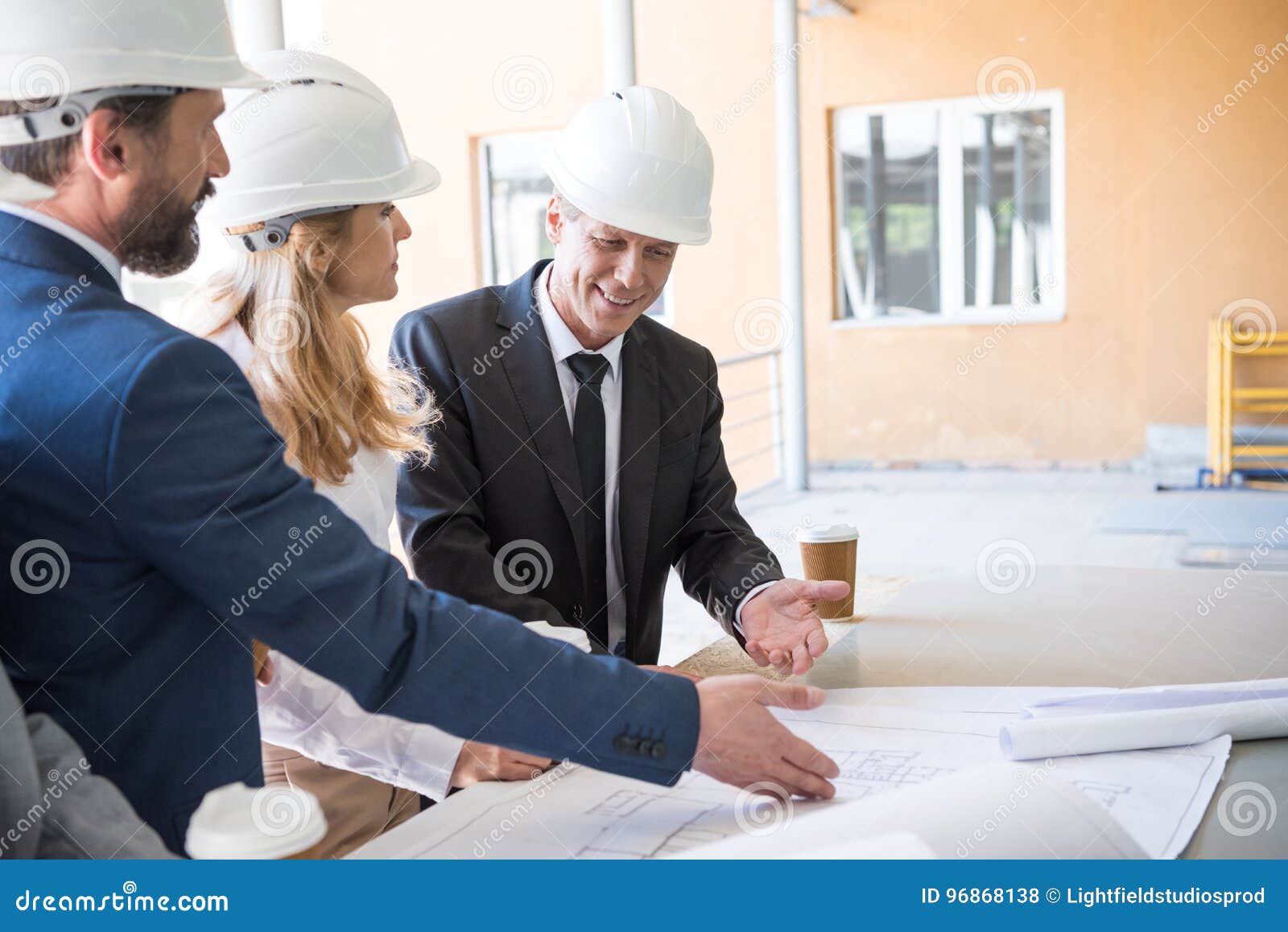Contractors in Formal Wear Working with Blueprints at Construction ...