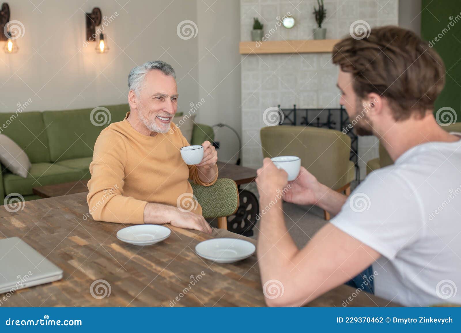 Two Men Sitting at the Table, Having Tea and Talking Stock Photo ...