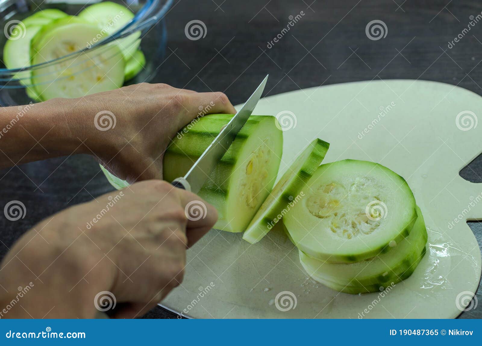 The Cook Cuts a Large Zucchini on a Cutting Board with a Knife into ...