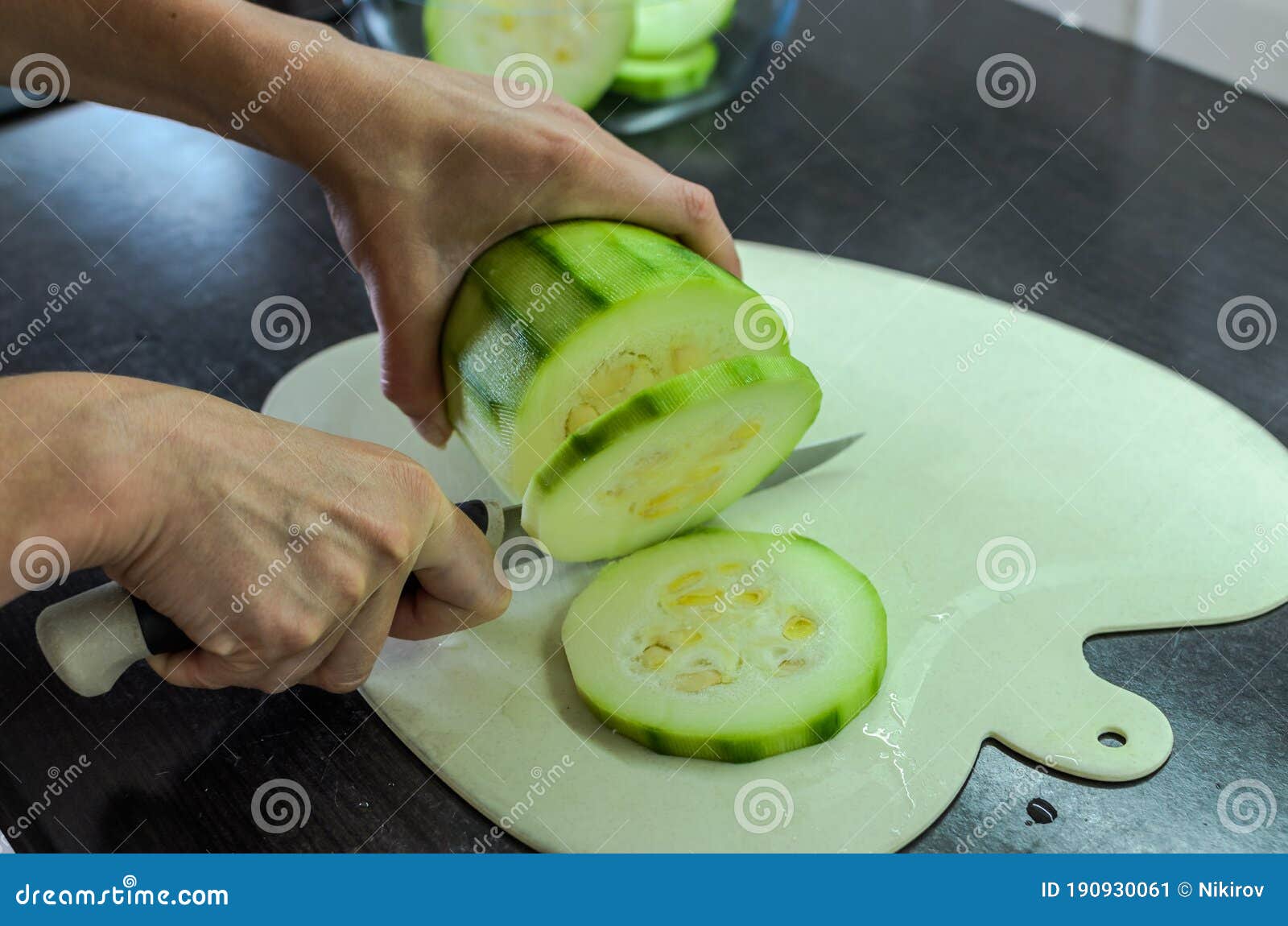 The Cook Cuts a Large Zucchini on a Cutting Board with a Knife into ...