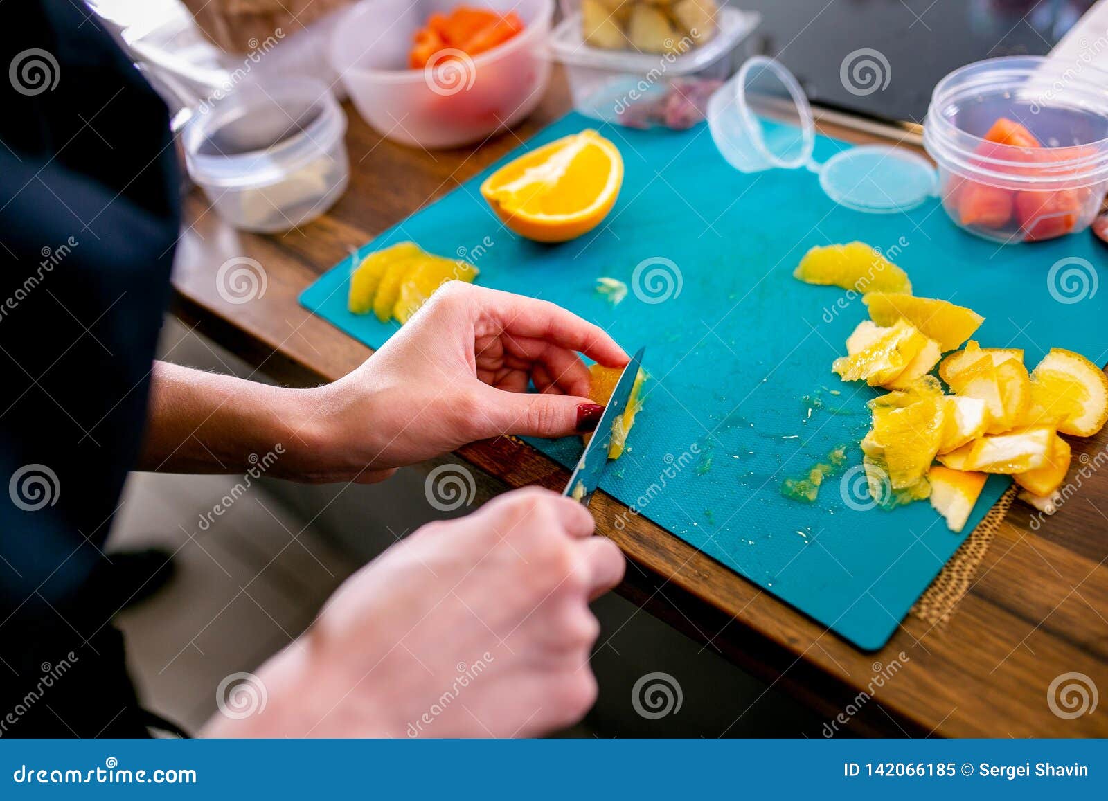 Cook Cuts an Orange on a Cutting Board. Master Class in the Kitchen ...