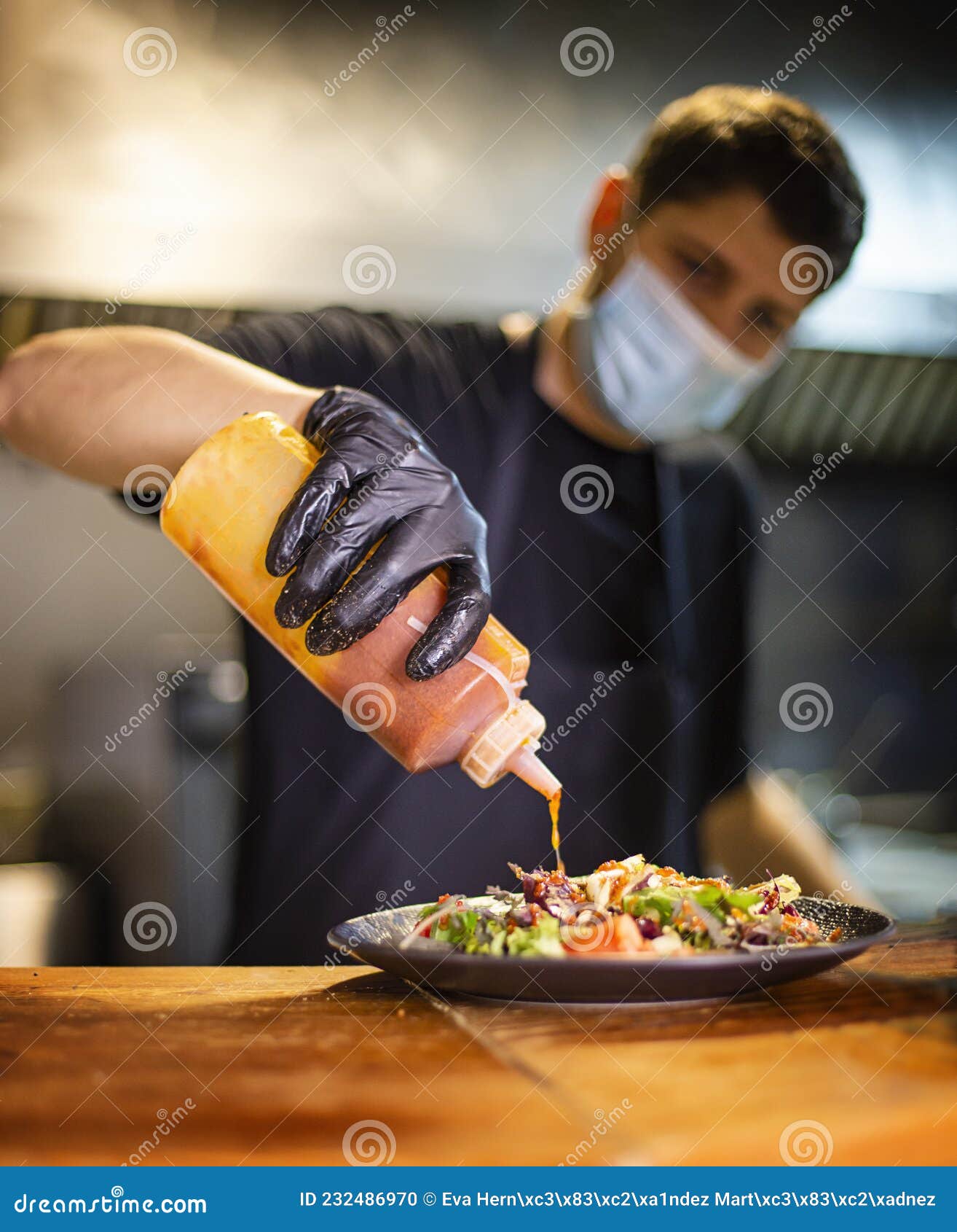 Cook in the Kitchen of a Restaurant Adding Sauce To a Salad Stock Photo ...