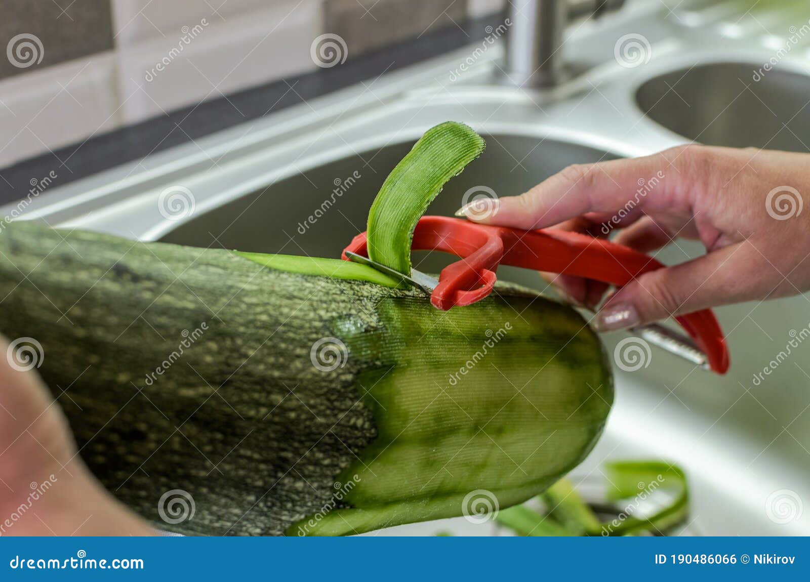 The Cook Peels a Large Zucchini with a Knife from the Peel Stock Photo ...