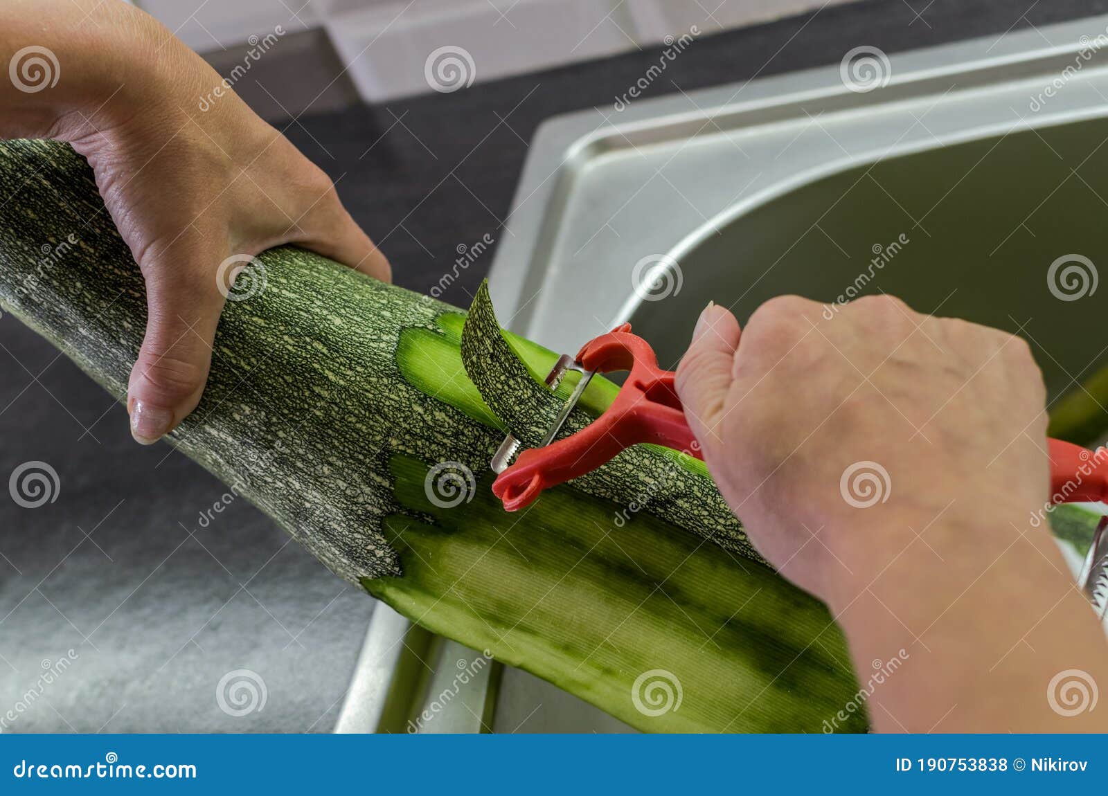 The Cook Peels a Large Zucchini with a Knife from the Peel Stock Photo ...