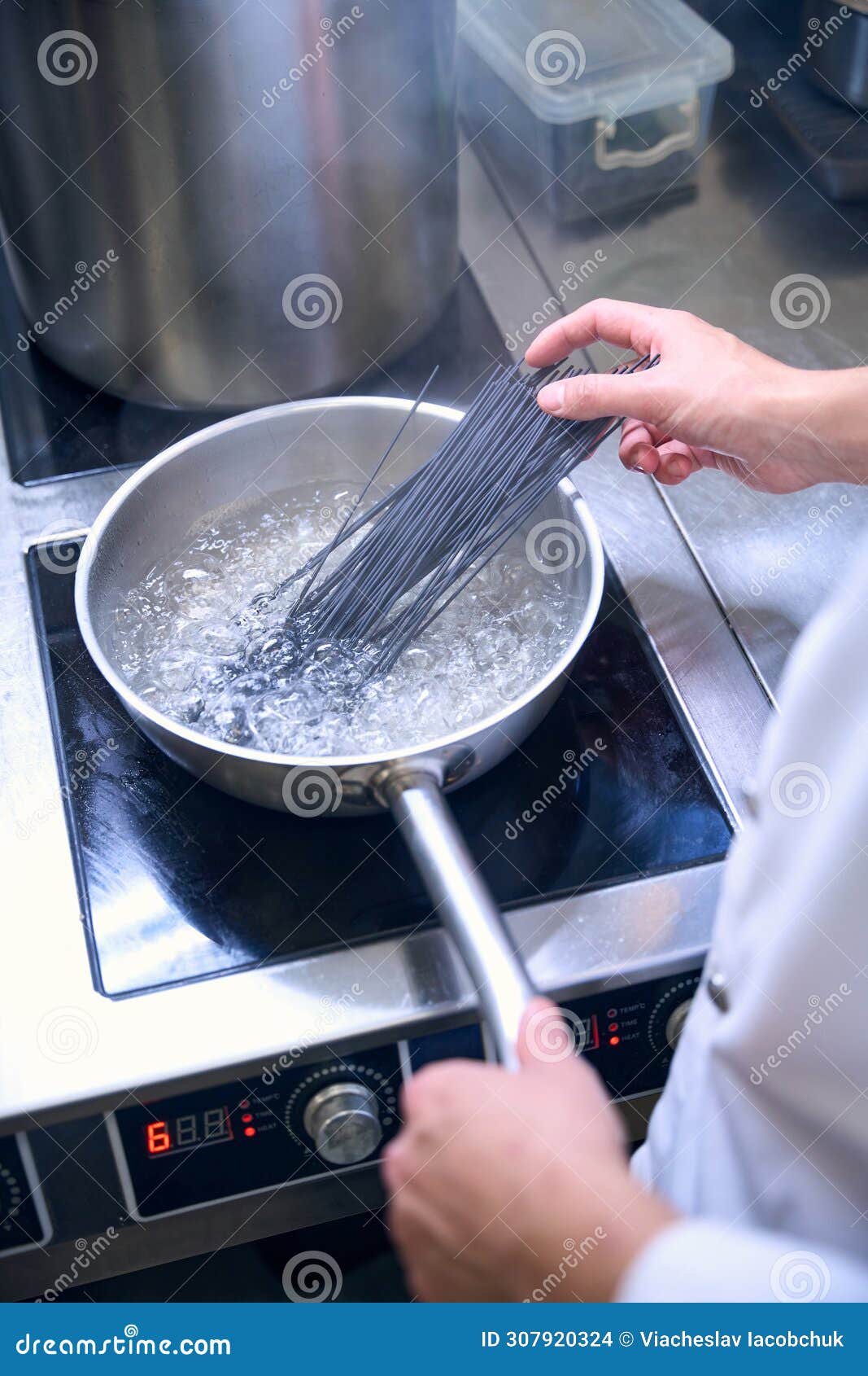 Cook Puts a Portion of Black Spaghetti into Boiling Water Stock Photo ...