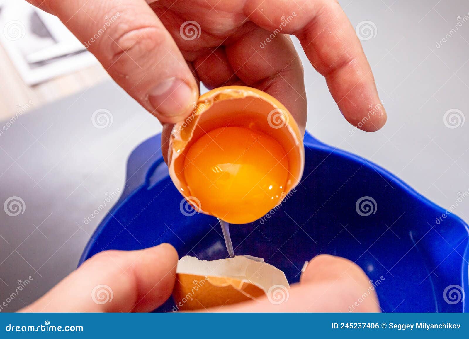 The Cook Separates the Egg Yolk from the Egg White in the Shell Stock ...