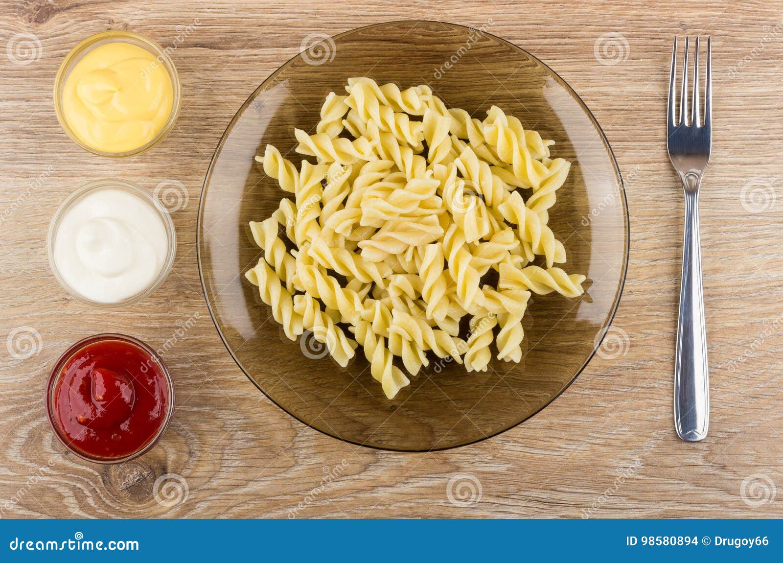 Cooked Pasta Fusilli in Plate, Different Sauces and Fork Stock Photo ...