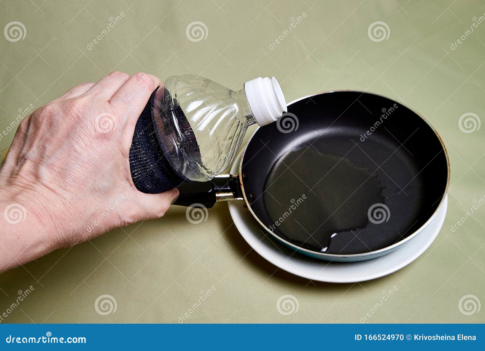 Cooking. a Bottle of Sunflower Oil in the Hand and Pouring Oil into the ...