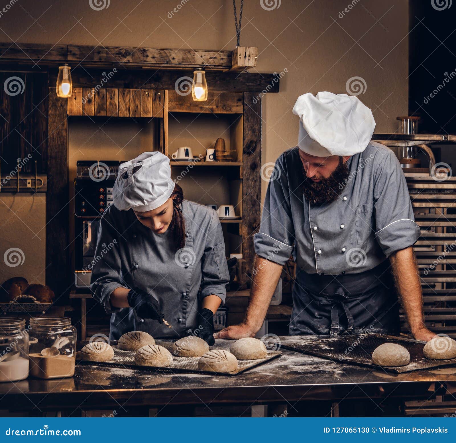 Chef Teaching His Assistant To Bake the Bread in a Bakery. Stock Photo ...