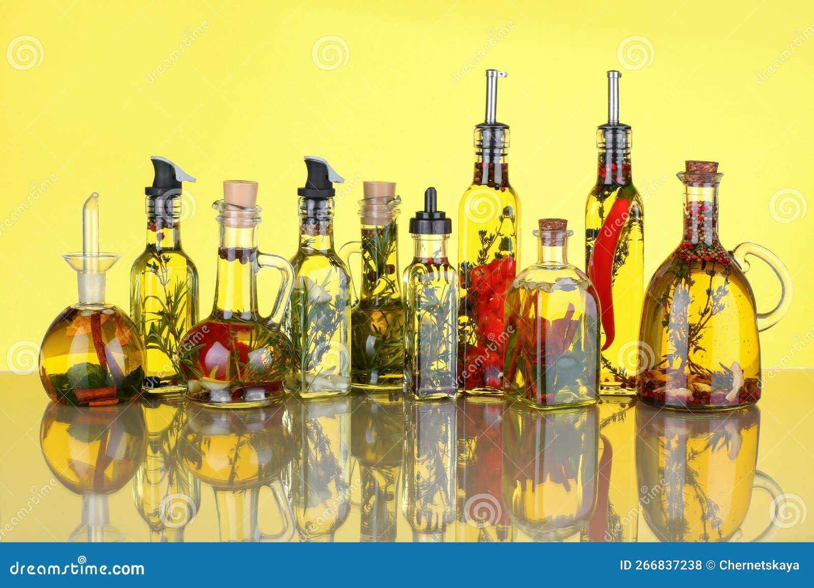 Cooking Oil with Different Spices and Herbs in Bottles on Yellow ...