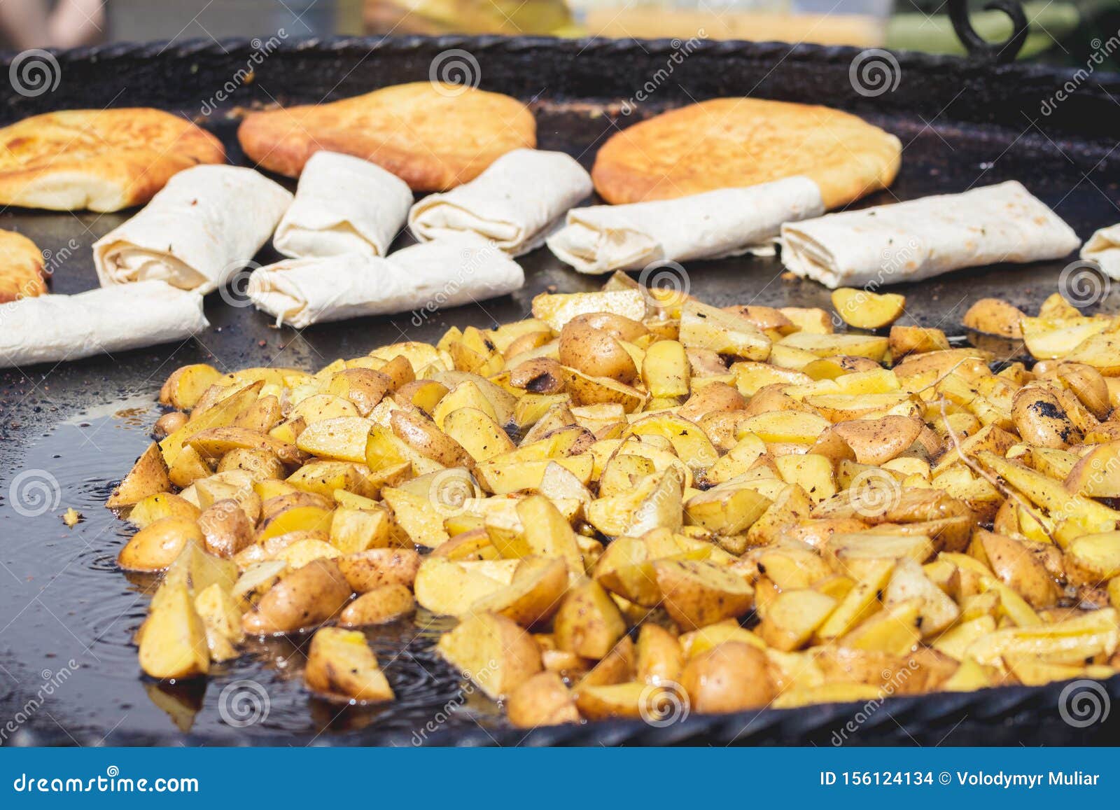 Cooking Potatoes on a Round Cast Iron Plate_ Stock Photo - Image of ...