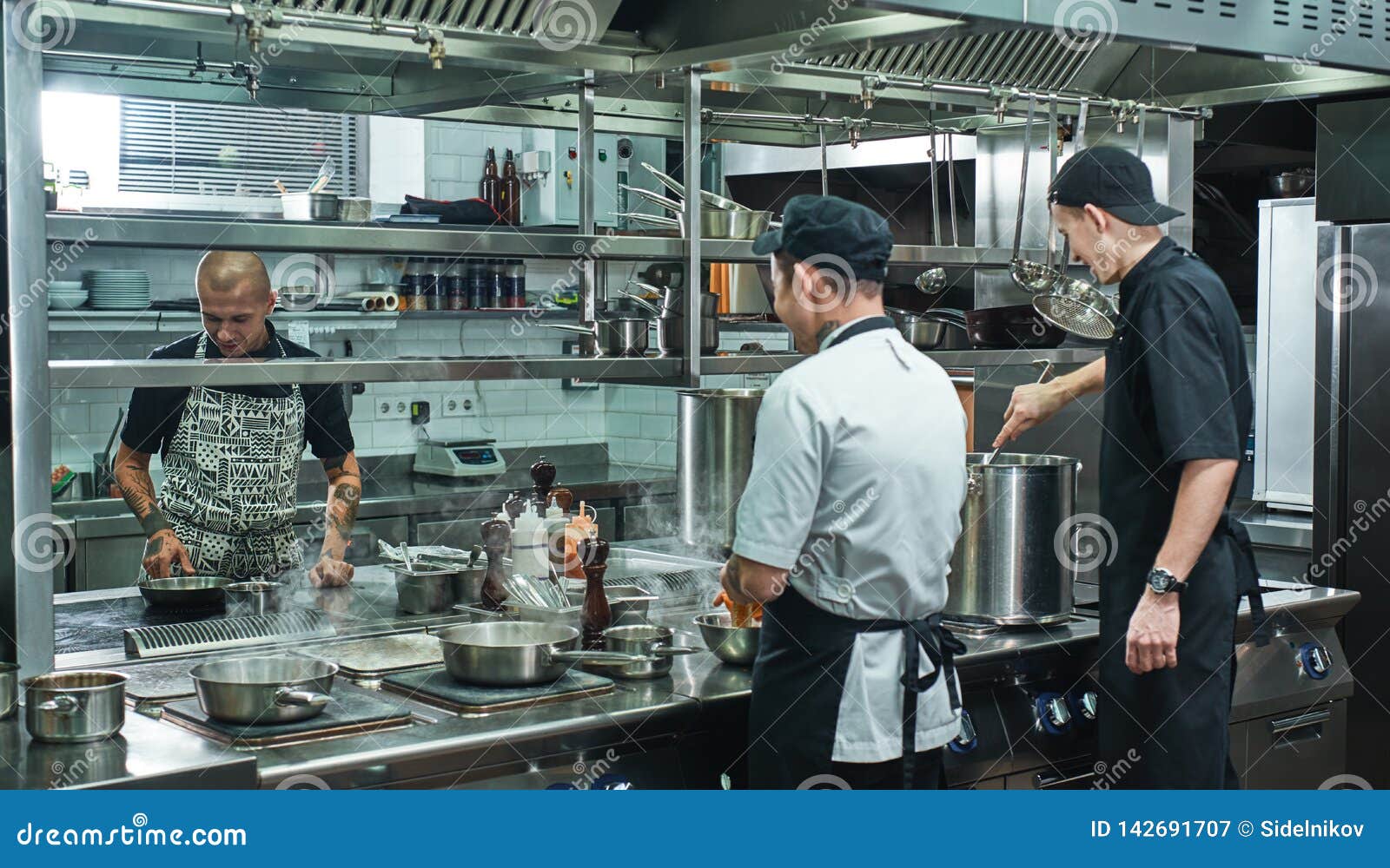 Cooking Process. Professional Team of Chef and Two Young Assistant ...