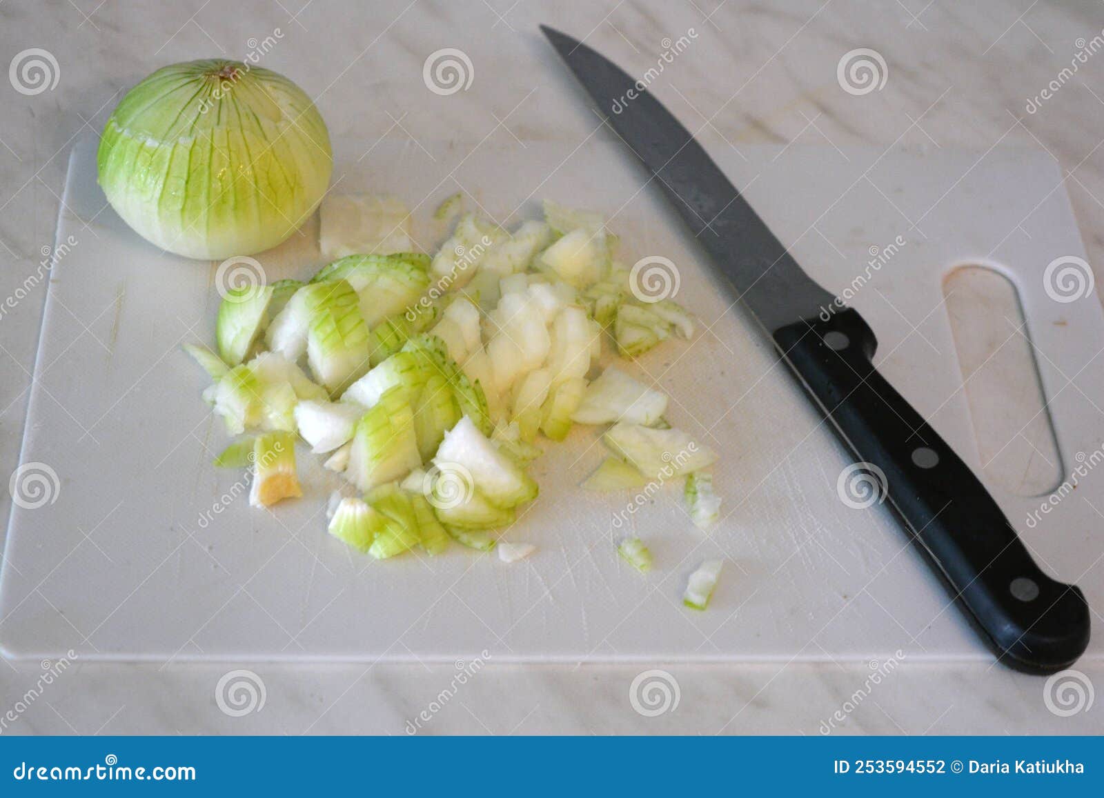 A Large White Green Onion and a Utility Knife with a Black Handle Lie ...