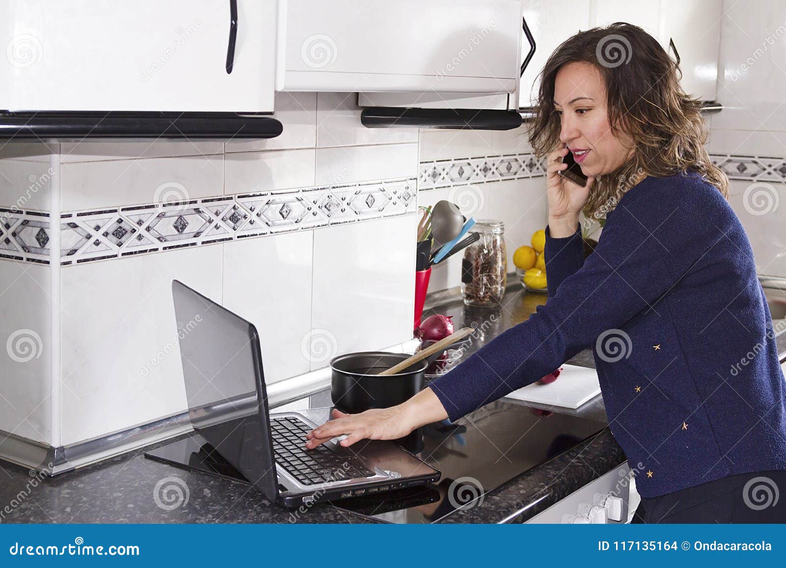 Cooking and using a laptop stock photo. Image of lifestyle - 117135164