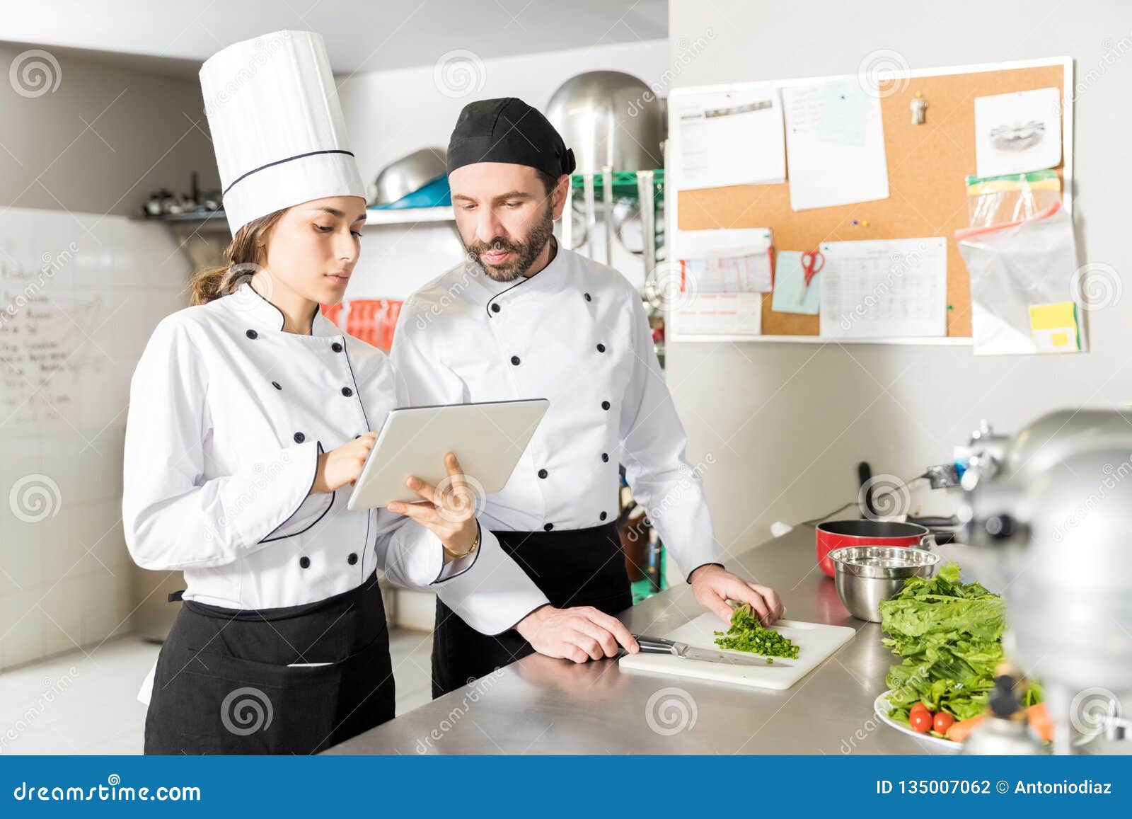 Cooks Using Tablet Computer in Restaurant Kitchen Stock Photo - Image ...