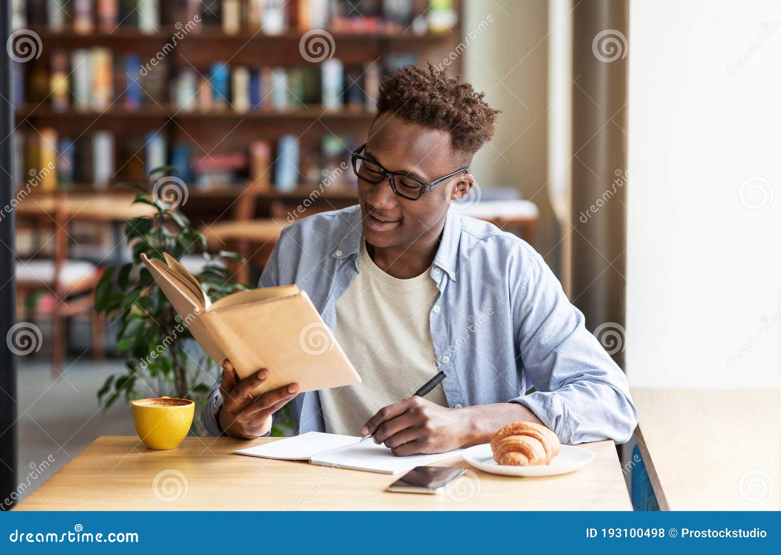 Cool Black Guy Reading Book and Taking Notes during His Studies at Cafe ...